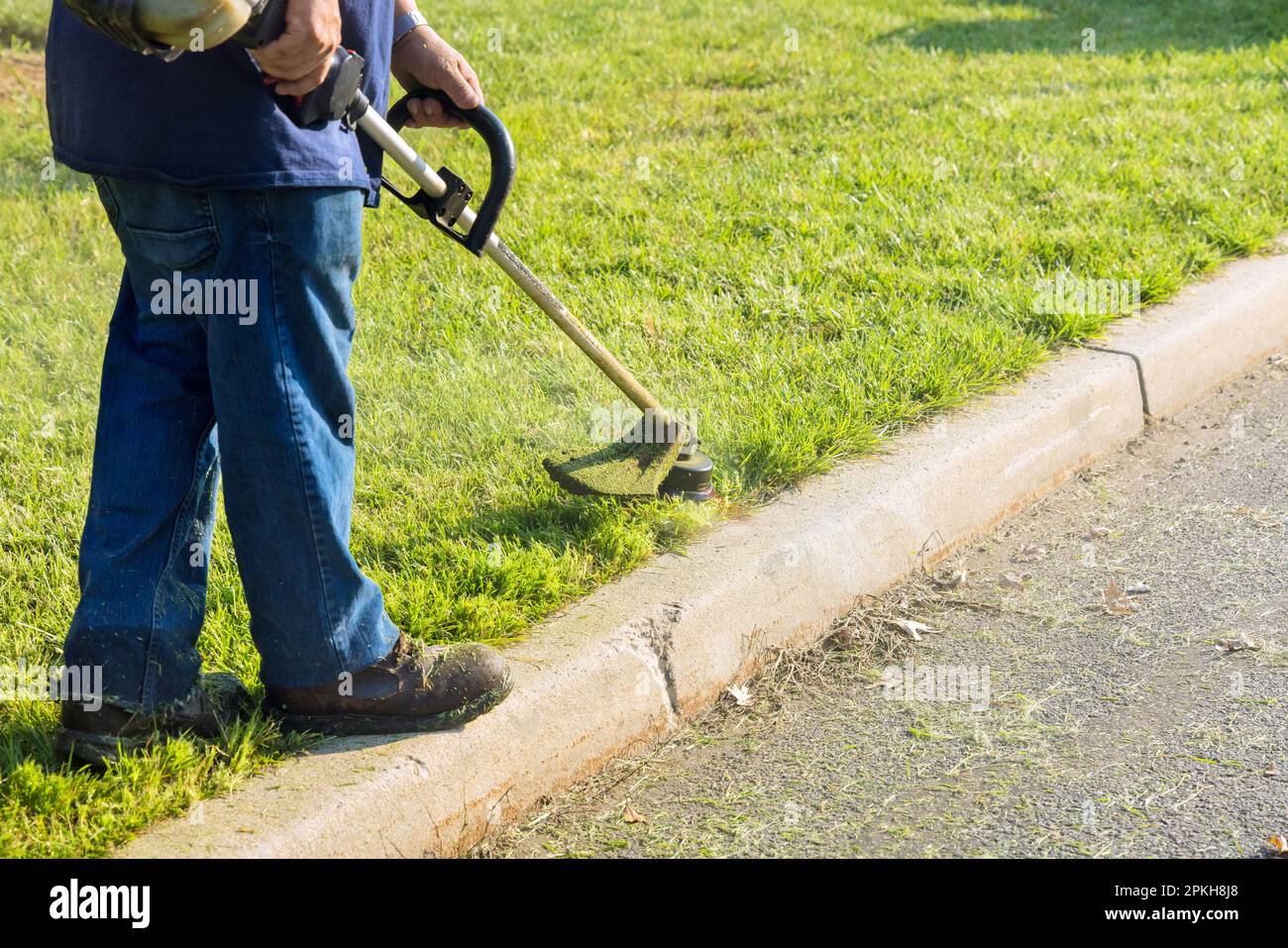 Municipal worker lawn mower close to road mows fresh green grass with ...