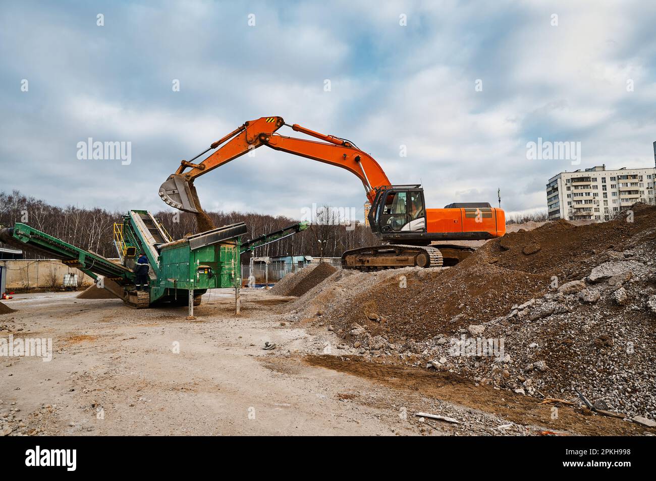 Excavator loads soil in mobile crushing and sorting complex Stock Photo ...