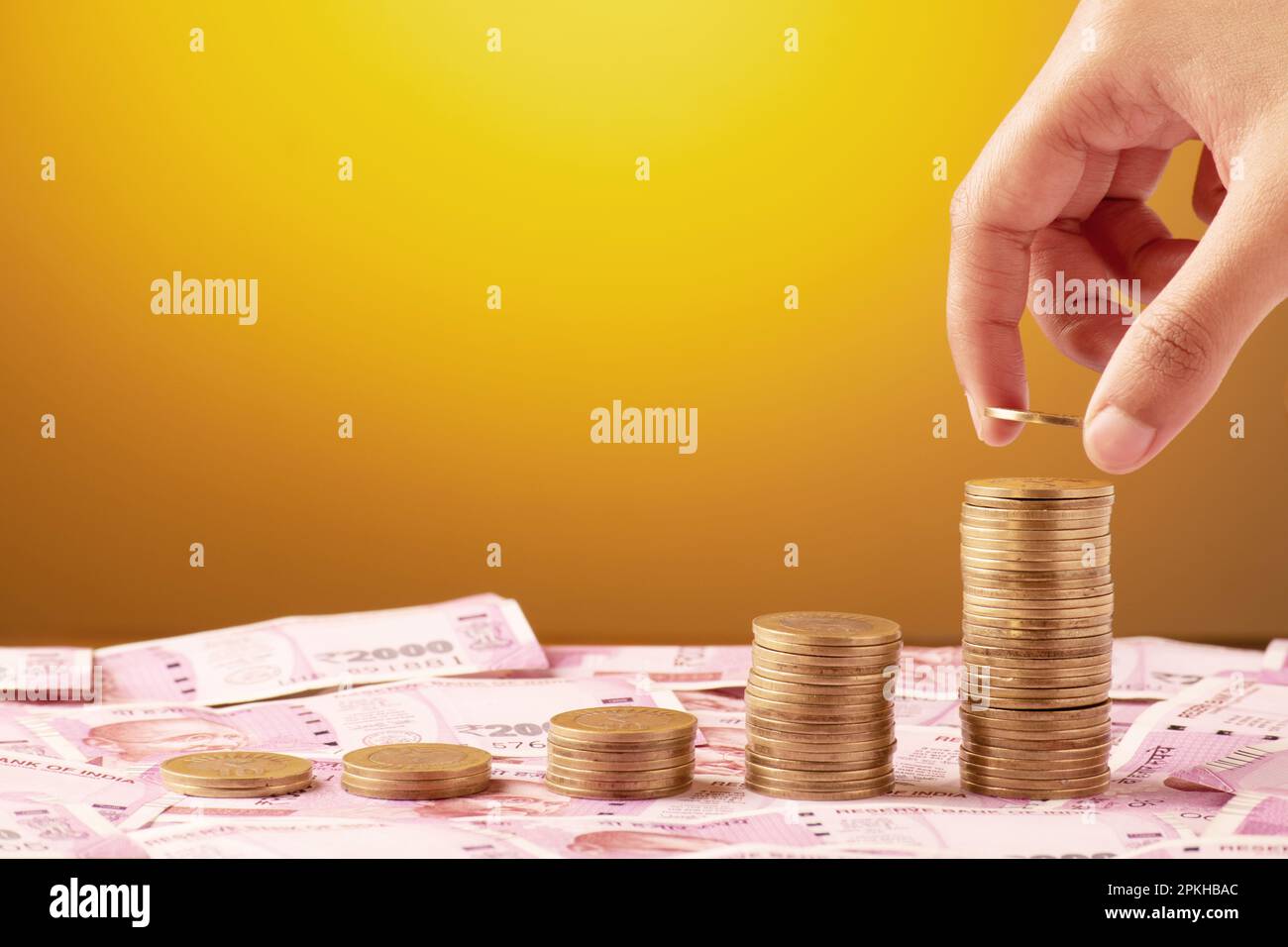 Putting coin in coin stack, wealth management concept Stock Photo - Alamy