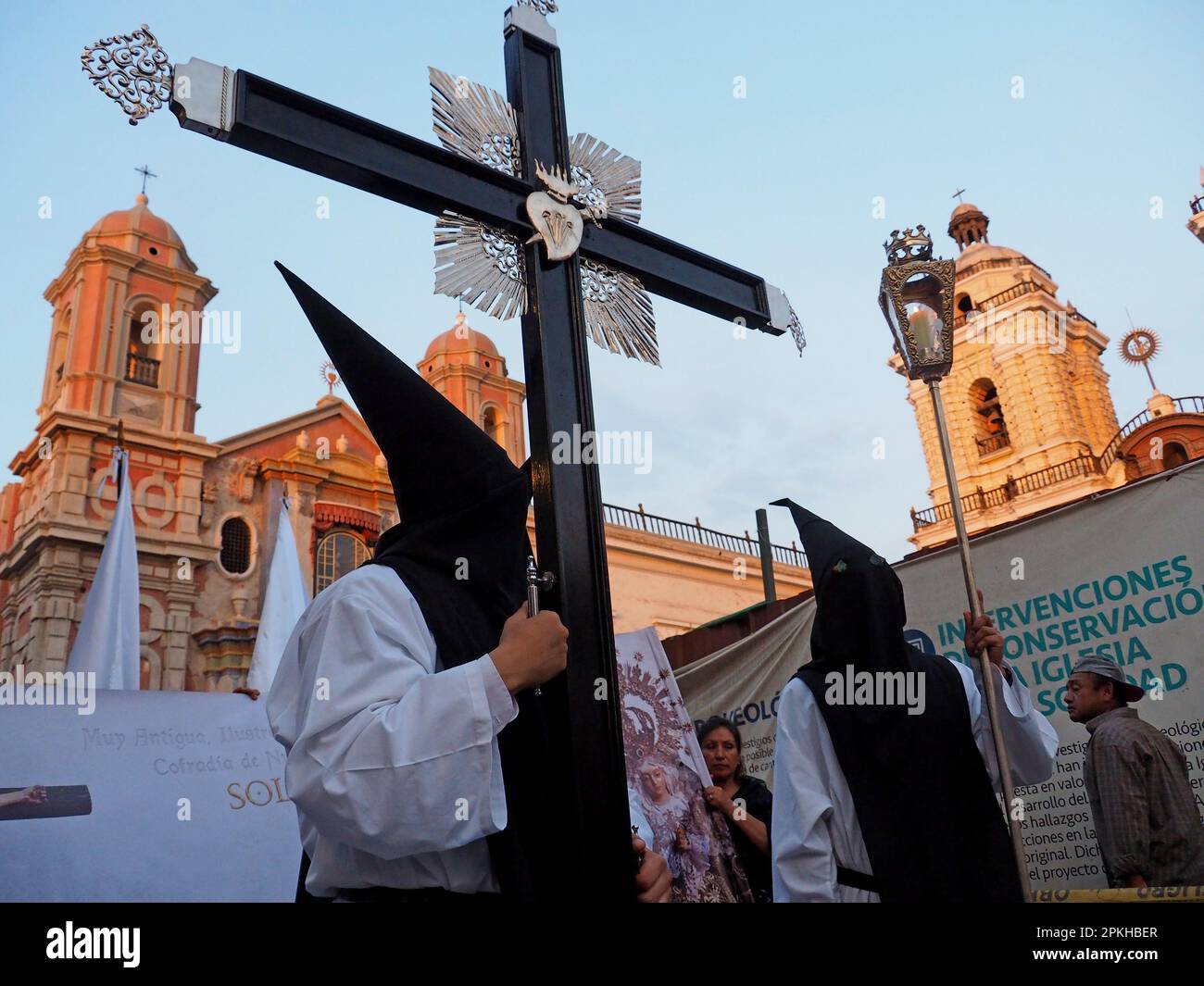 Hooded catholic devotees carrying on a religious procession at eve on ...