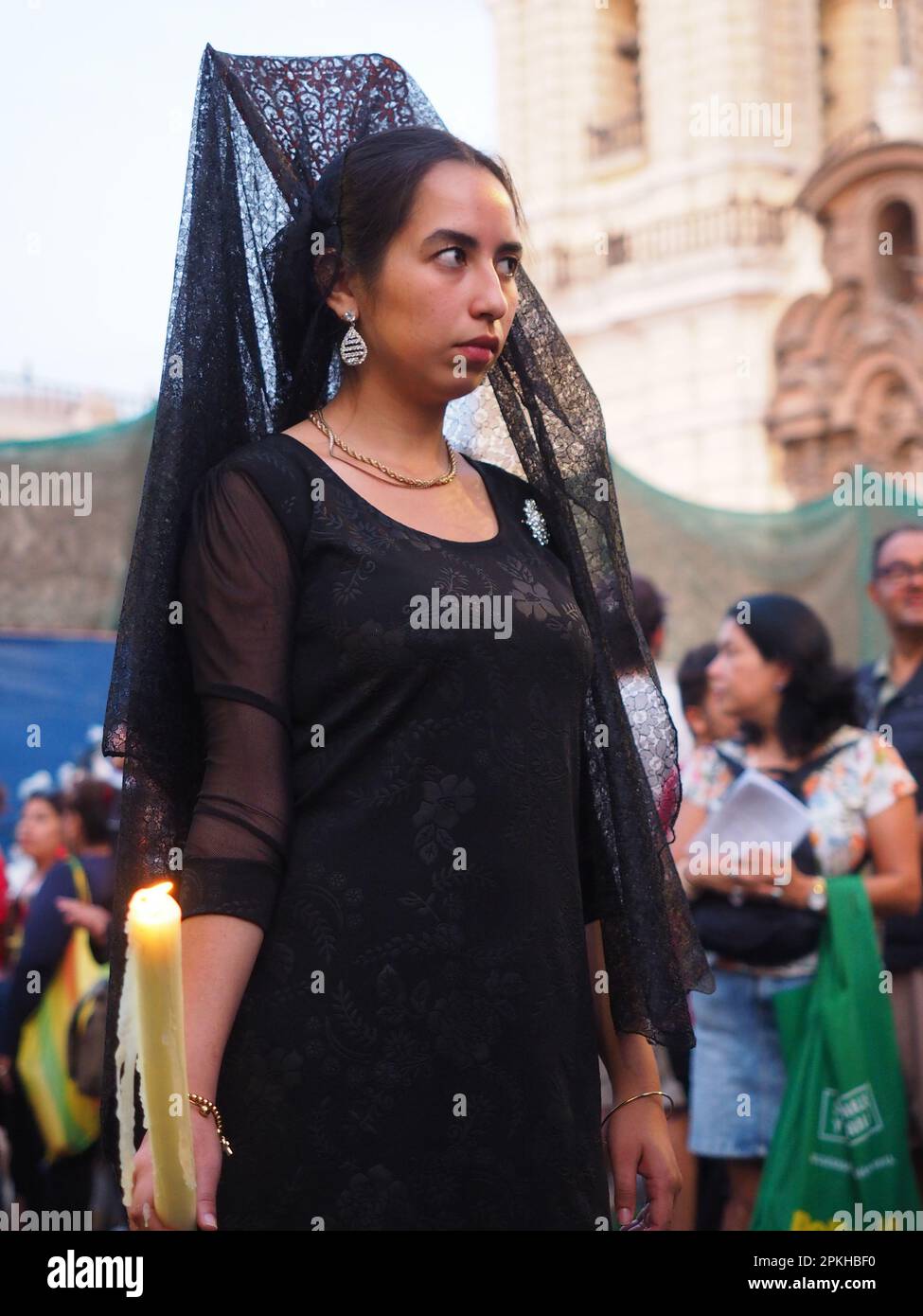 Black dressed female devotees wearing mantilla and comb, carrying ...