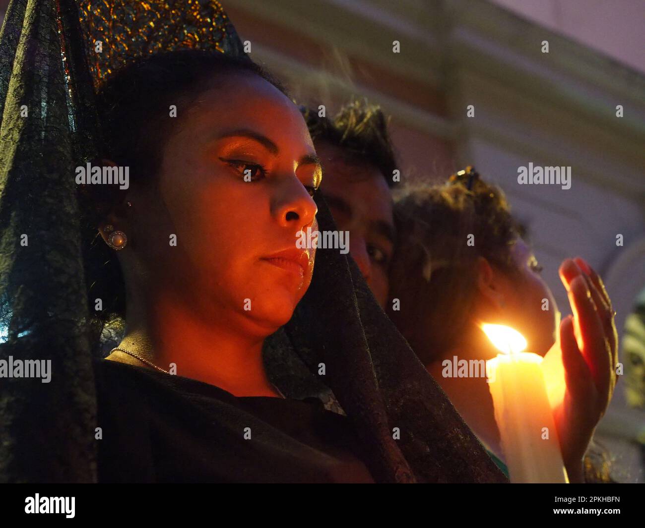 Black dressed female devotees wearing mantilla and comb, carrying ...