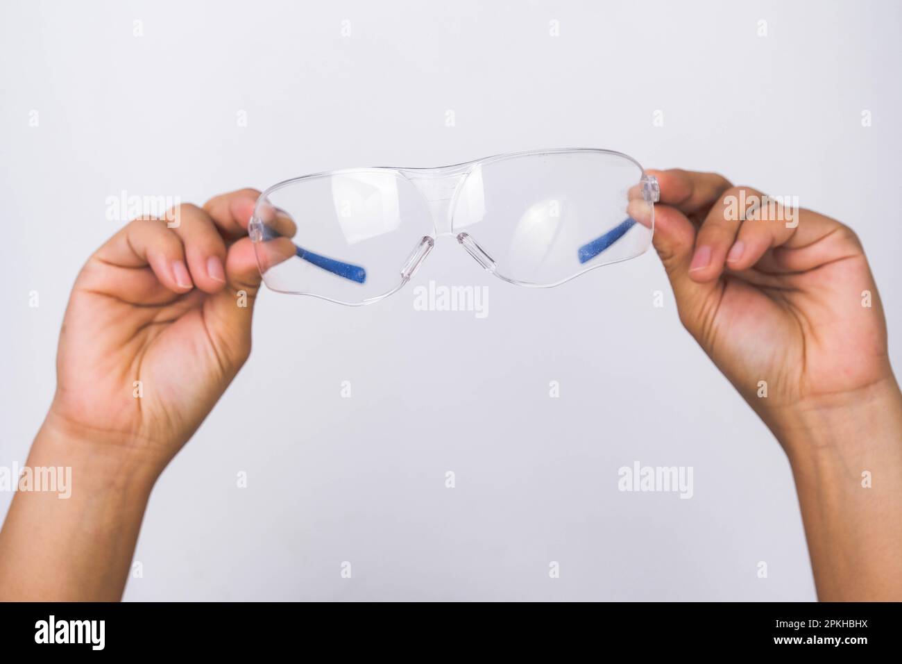 Hand holding safety glasses, personal protective equipment. Protective ...