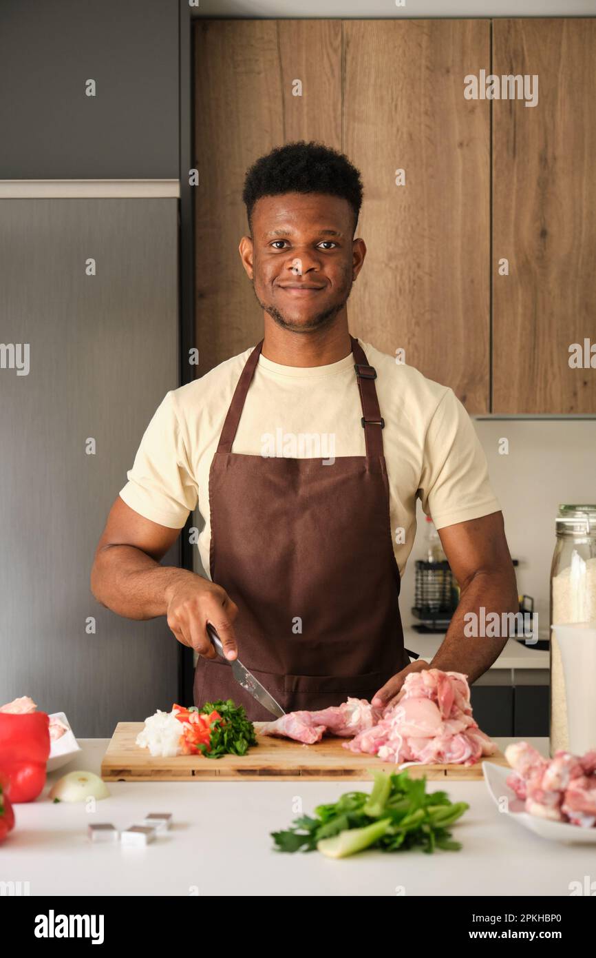 Young black man de-boning chicken to prepare a recipe Stock Photo - Alamy