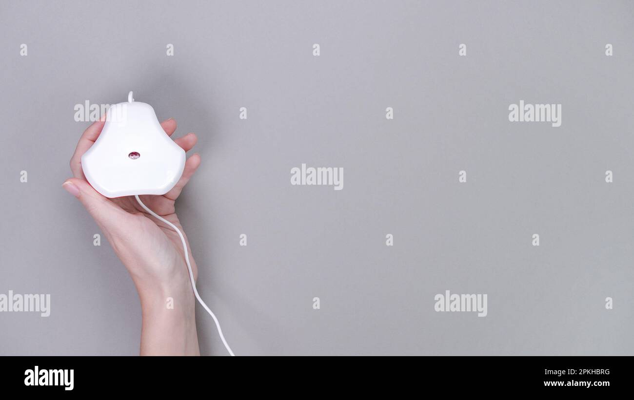 Hands holding white monitor calibrator on the grey background ...