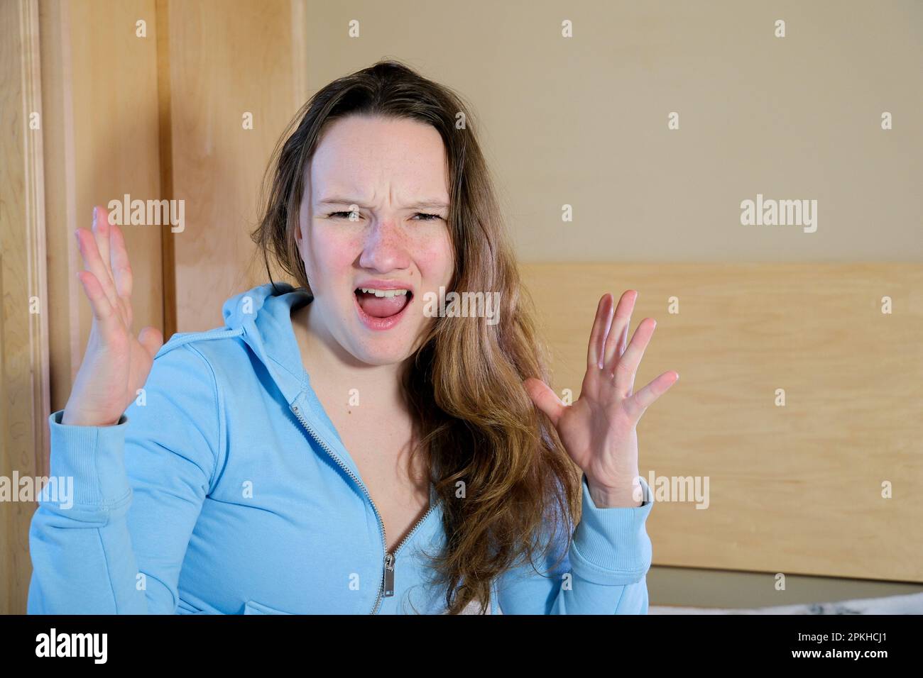 Redhead woman wearing easter rabbit ears at home annoyed and frustrated ...