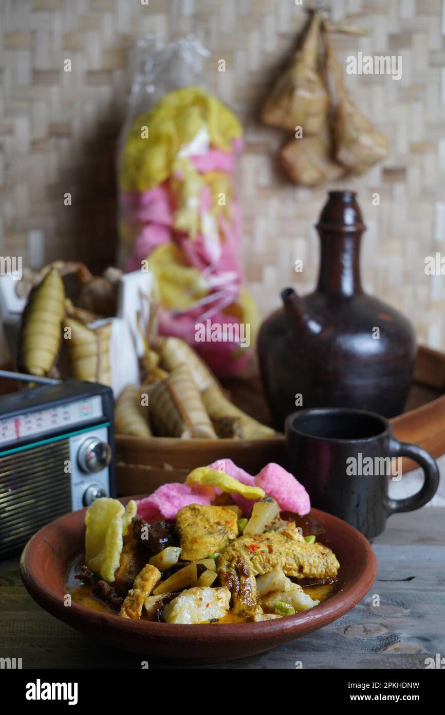 Ketupat or rice filled woven palm leaf served with opor ayam or chicken ...