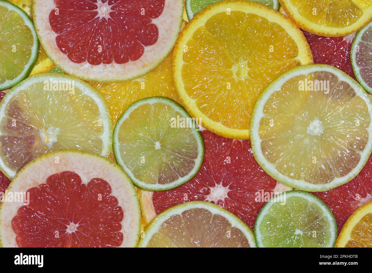 A flat, top view of an assortment of shiny, fresh, juicy orange, lime ...