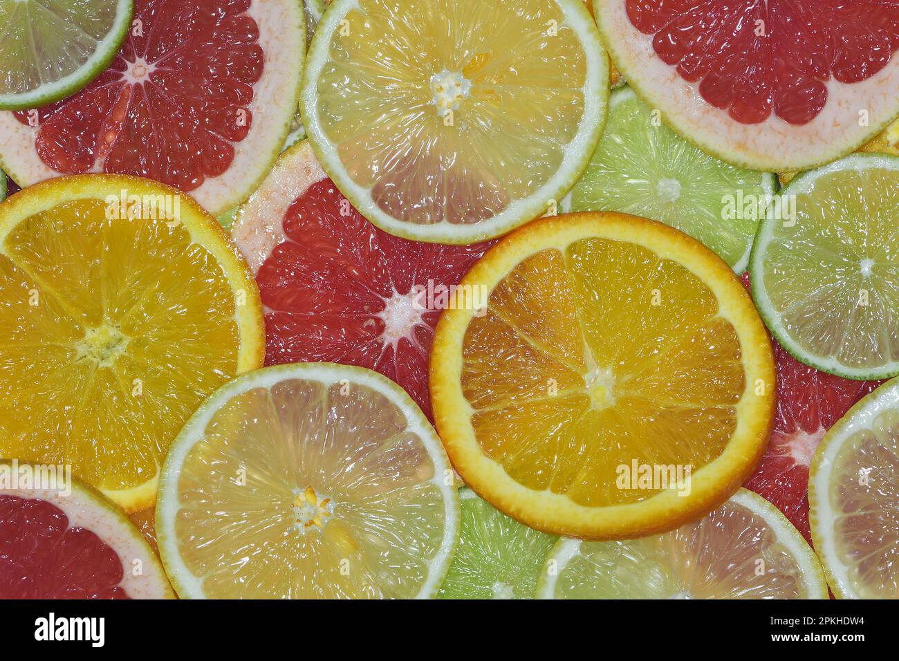 A flat, top view of an assortment of shiny, fresh, juicy orange, lime ...