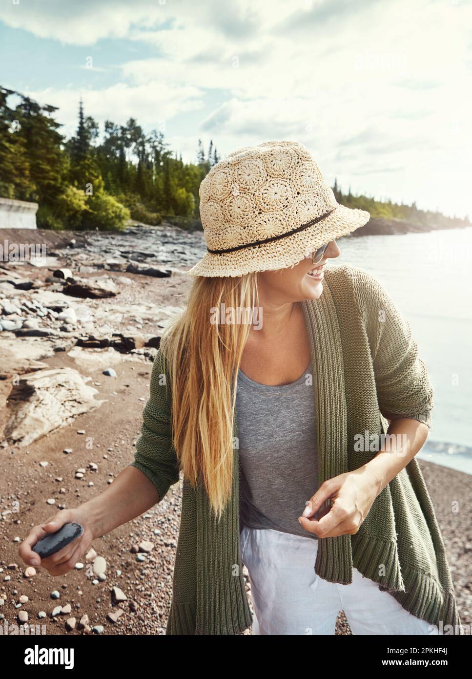 Trying to beat her own stone throwing record. a young woman throwing ...