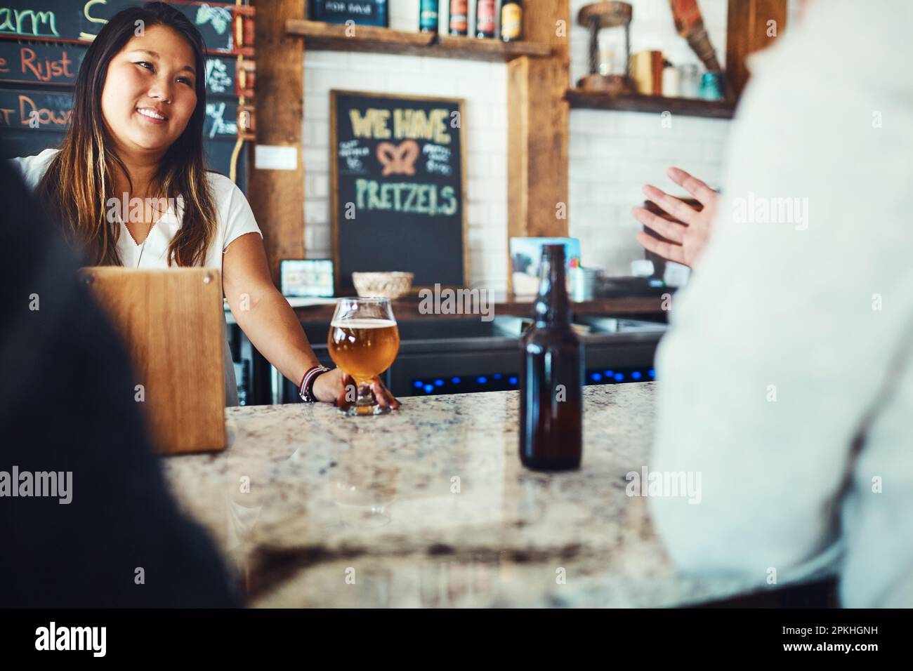 The best service in town. a young woman serving drinks in a bar Stock ...