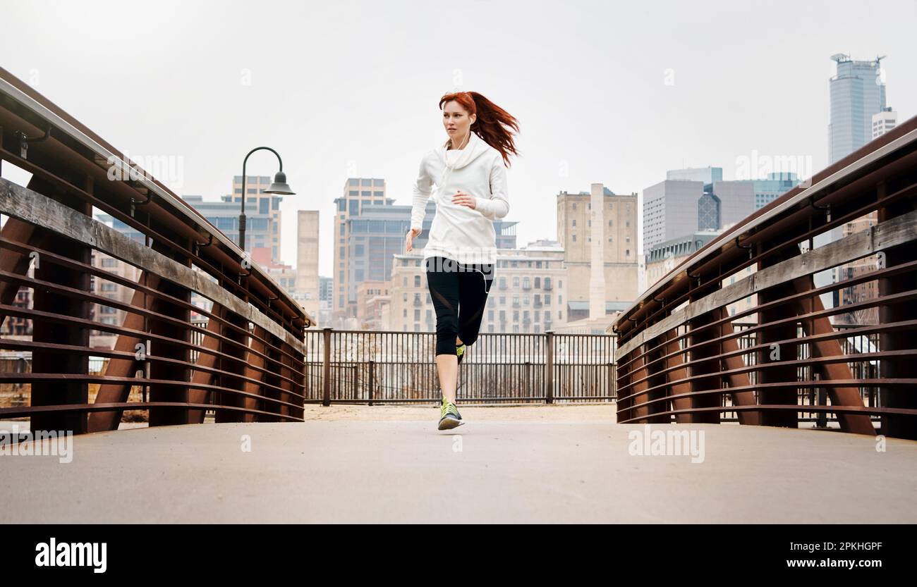 Keep pushing on and youll soon conquer. a sporty young woman listening ...