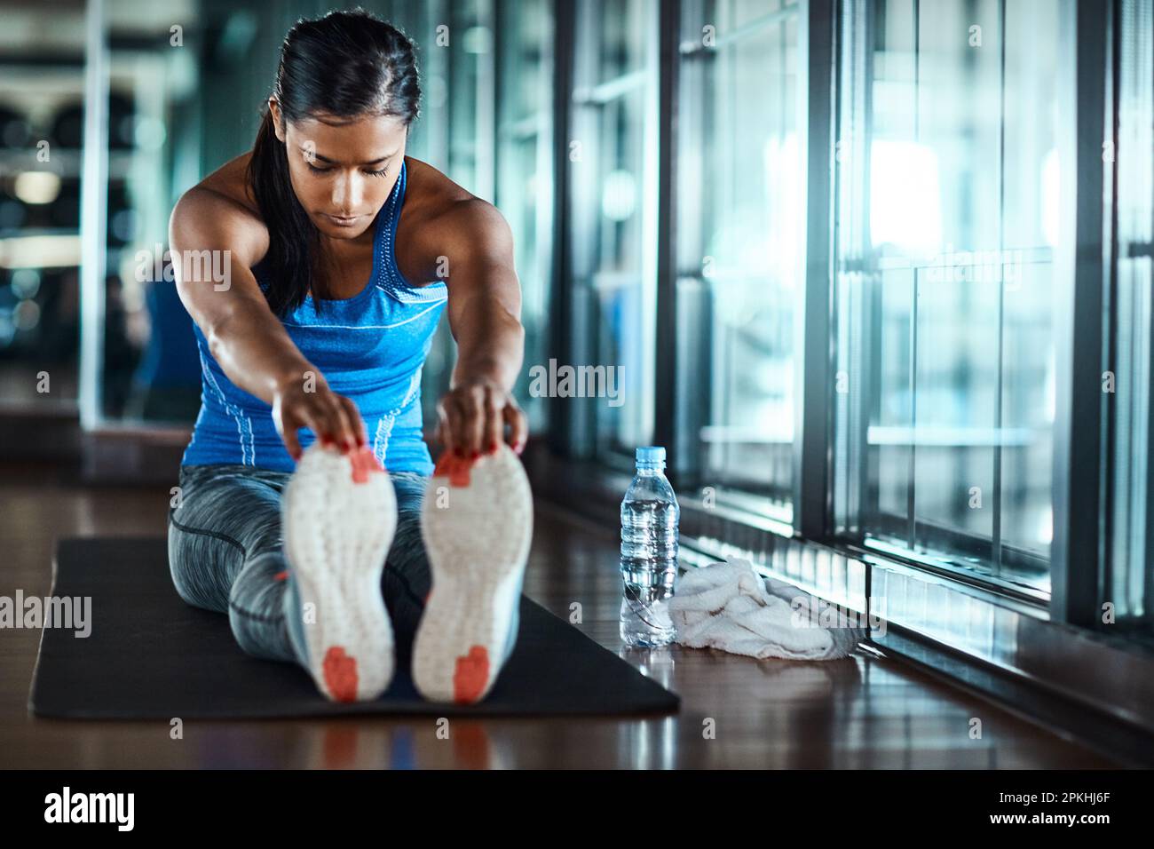 Stretching should always be the first step. an attractive young woman ...