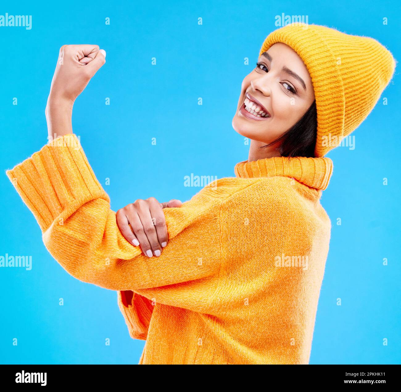 Happy, arm and portrait of a woman with muscle isolated on a blue ...