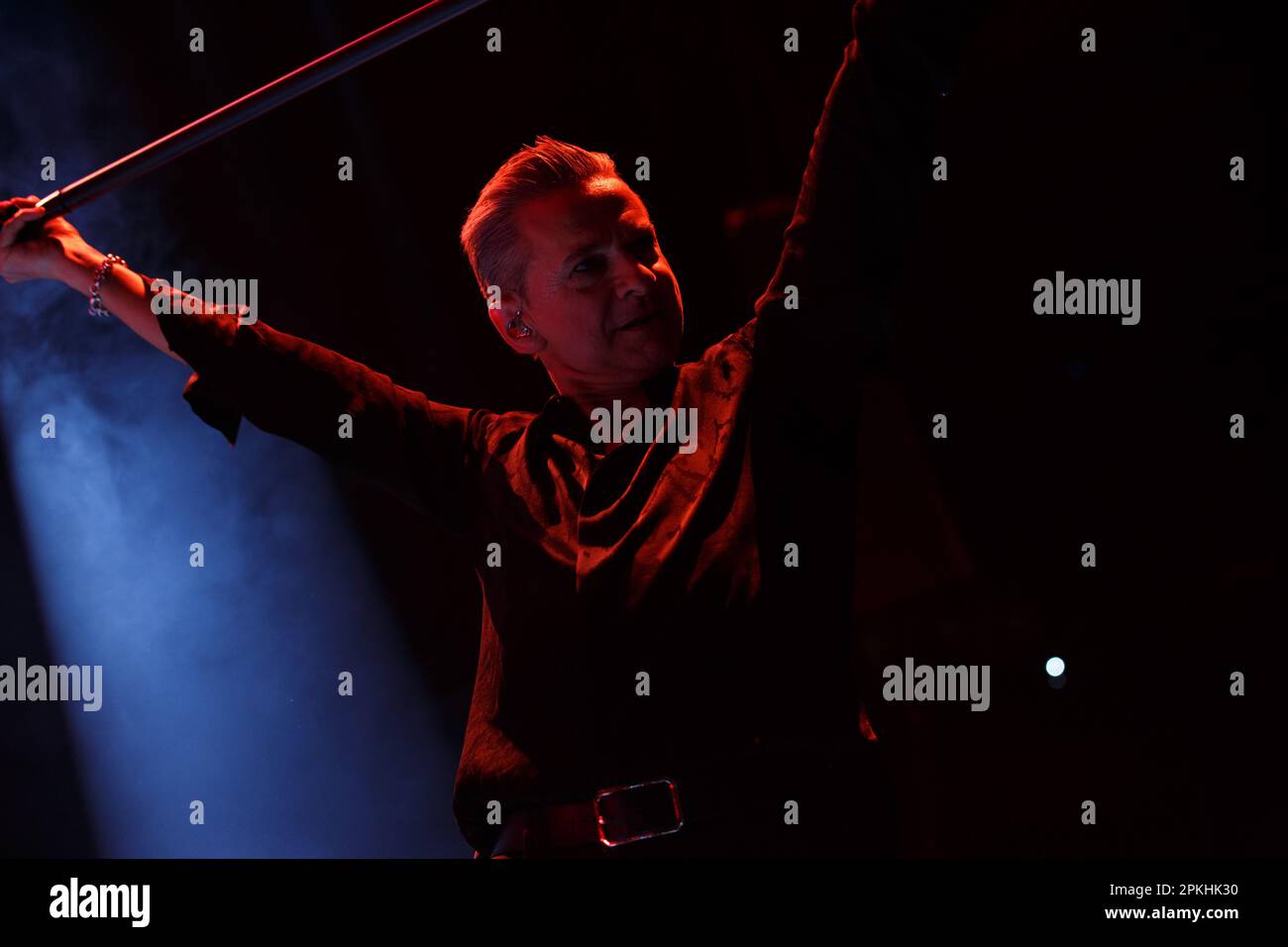 Depeche Mode lead singer Dave Gahan weilding a microphone stand while ...