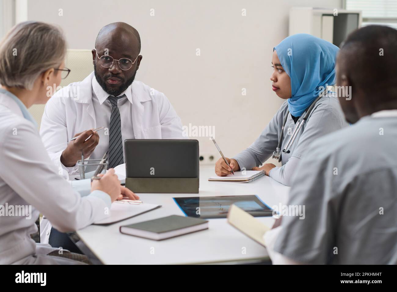 Group of professional doctors discussing difficult disease of patient ...