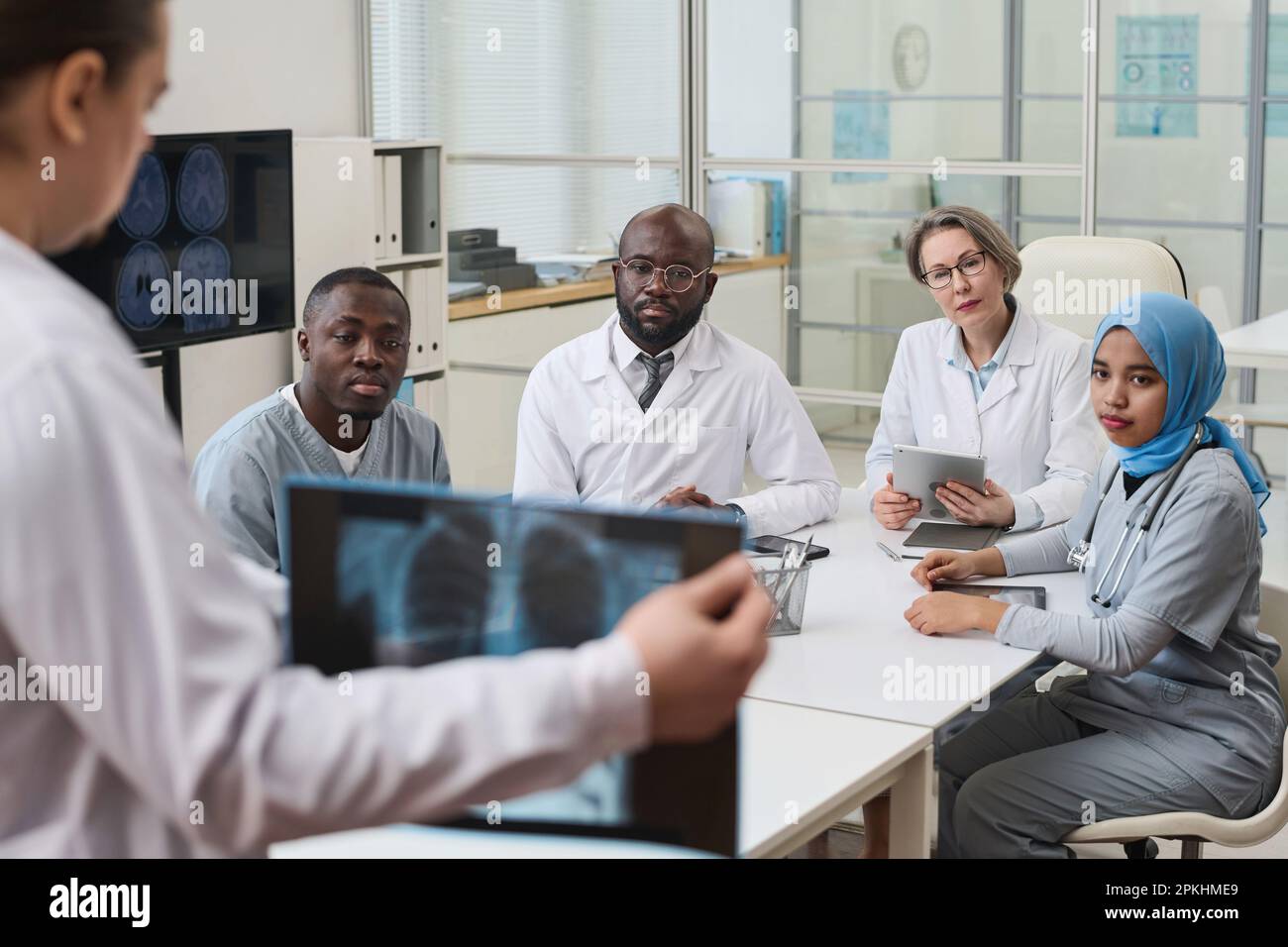 Doctor showing x-ray image of lungs to his colleagues and discussing ...
