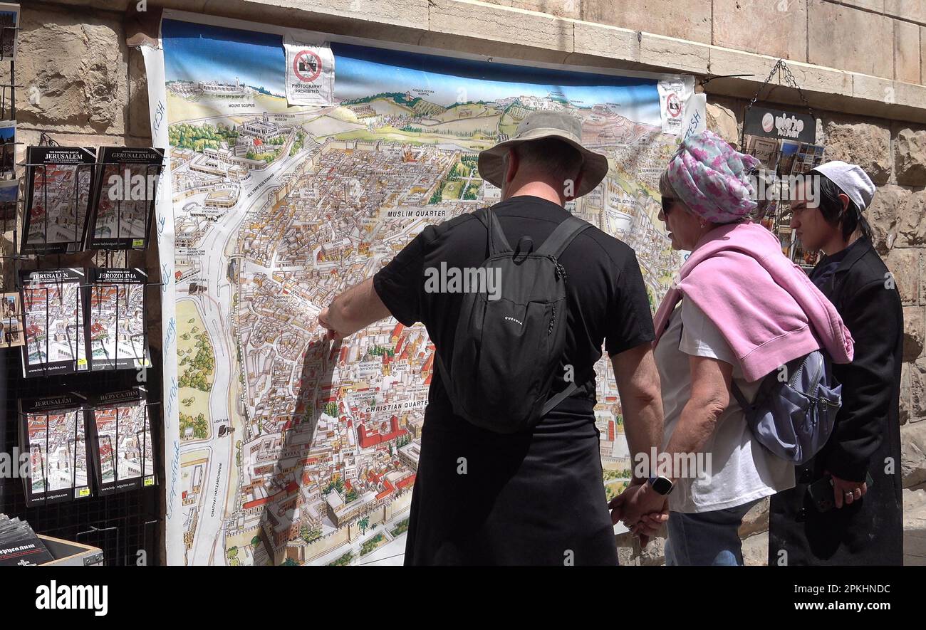 Tourists look at the map of the old city and try to find their way in ...