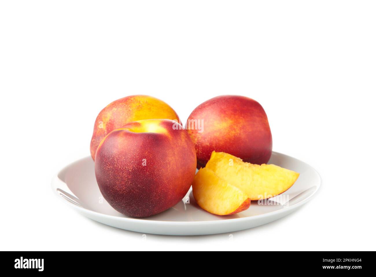 Nectarines in grey plate isolated on white. Top view Stock Photo - Alamy