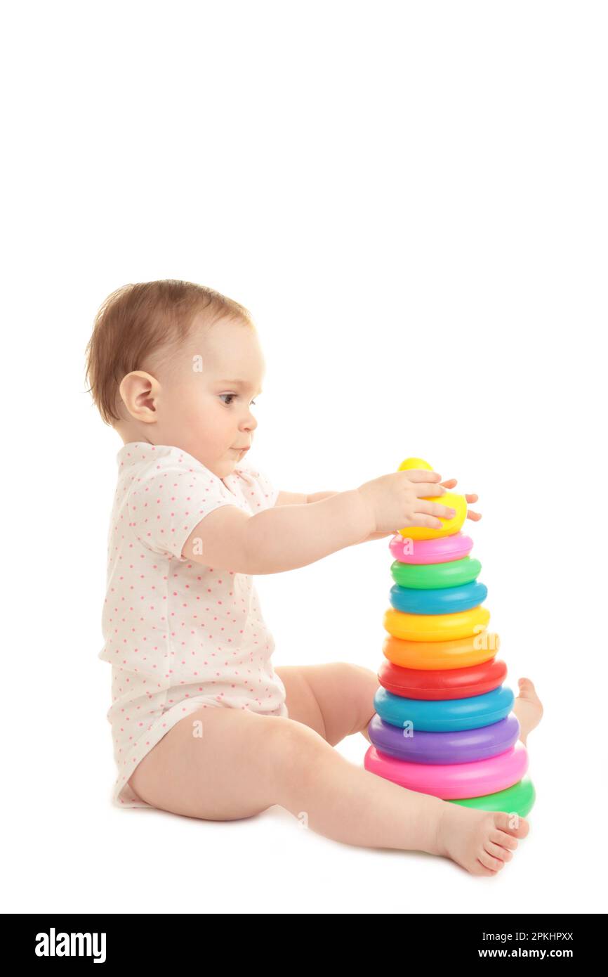 Cute baby playing with colorful rainbow pyramid isolated on a white ...