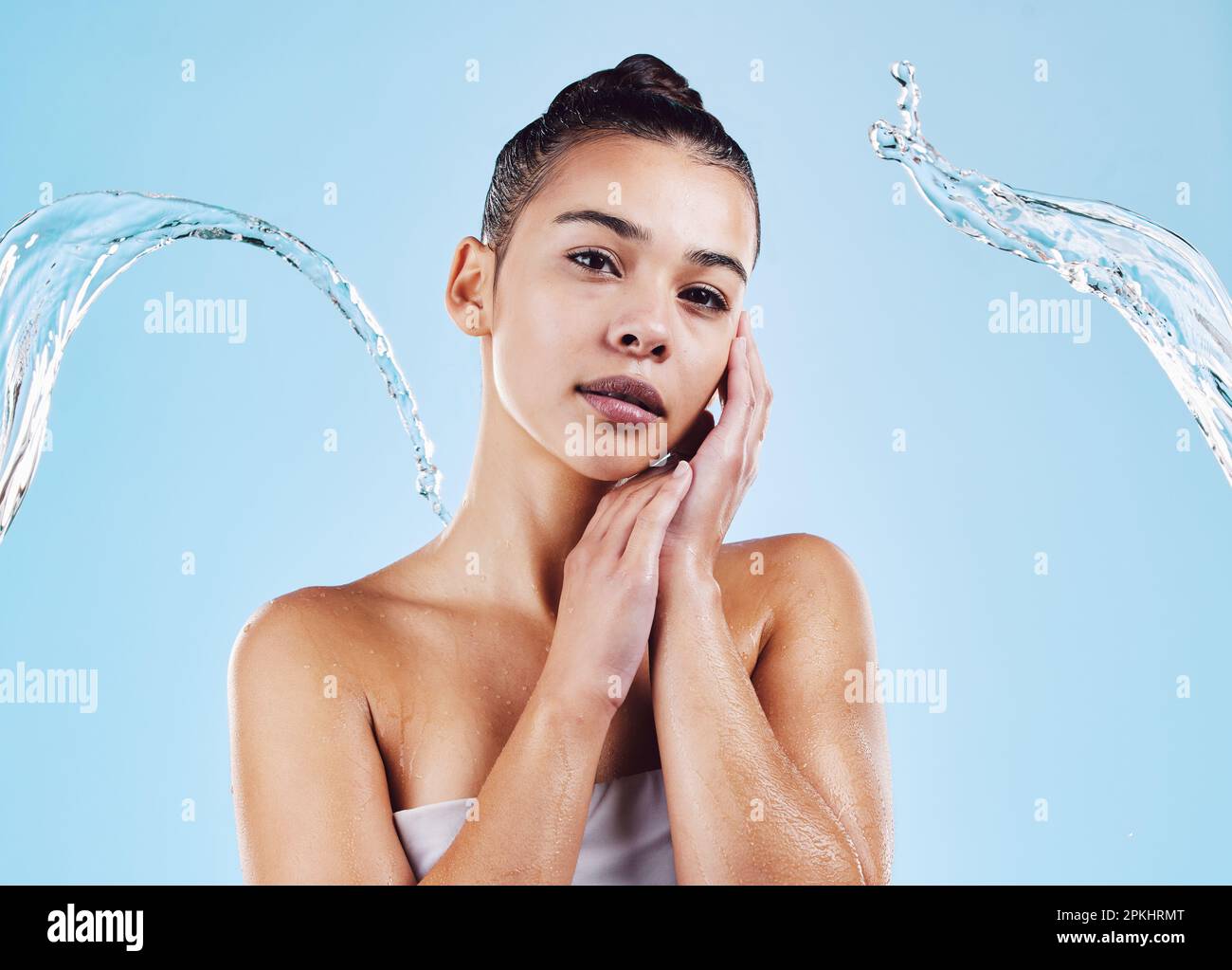 Water splash, portrait and woman shower in studio, blue background and ...