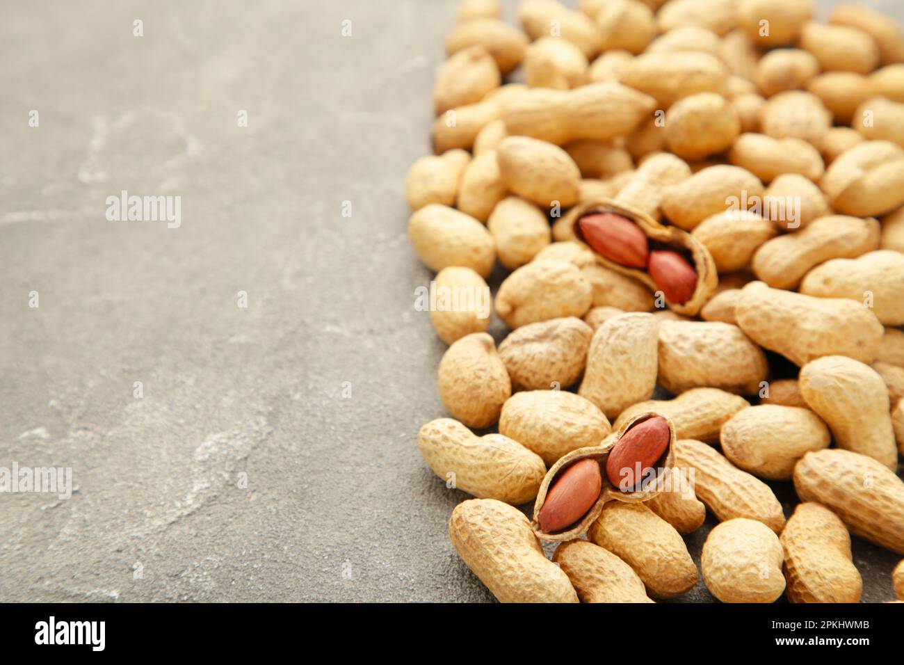 Peanuts in shells on grey concrete background. Top view Stock Photo - Alamy