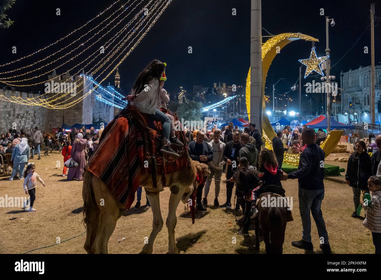 Children ride a camel as Palestinians gather in front of Damascus Gate ...