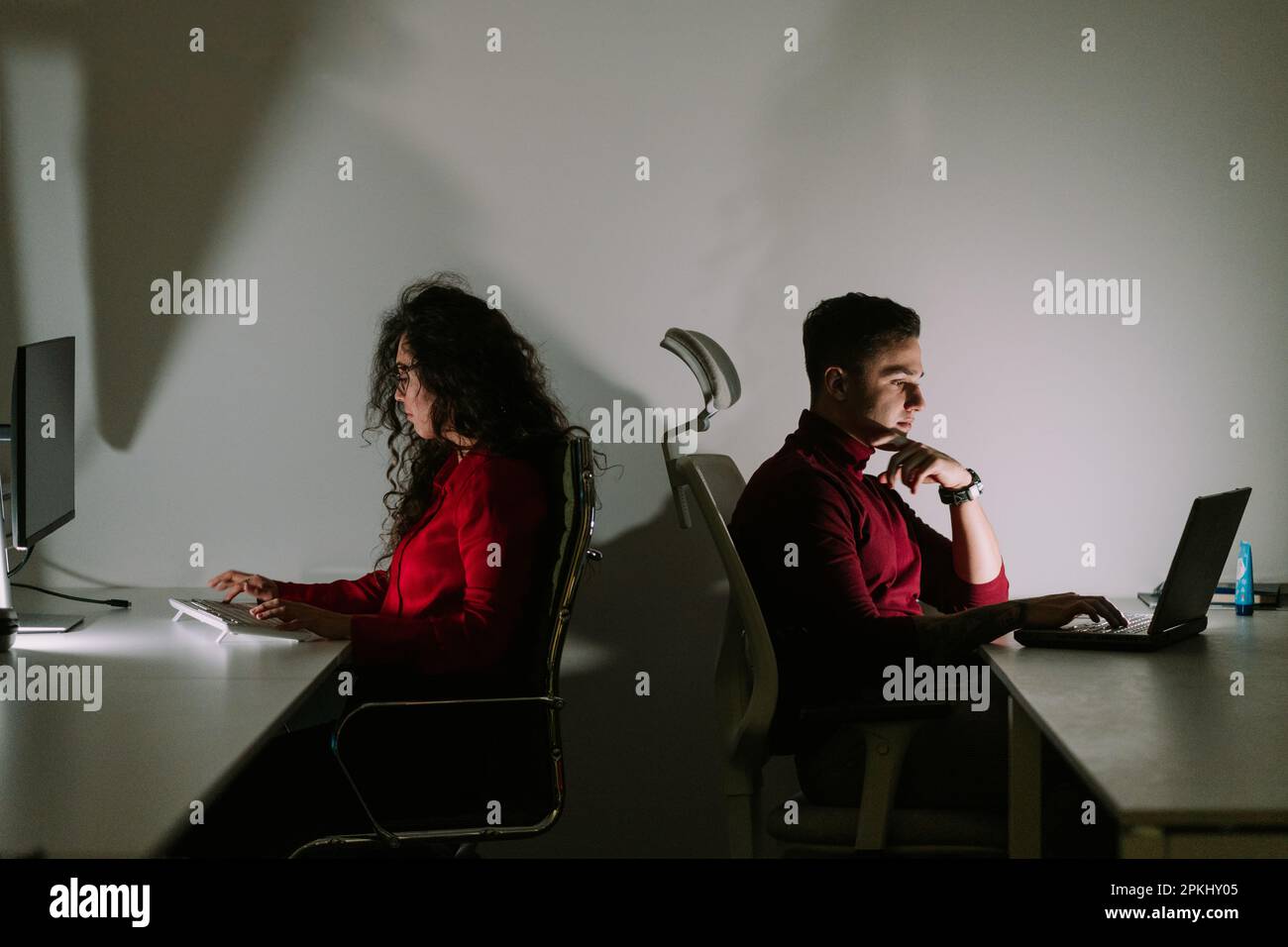 Lights out at the office. Young male and female colleagues working late ...