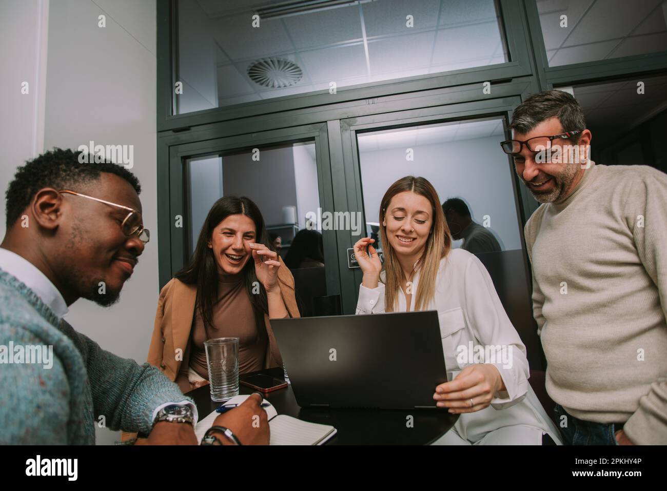 Four smiley inter-generational multiracial colleagues having fun while ...