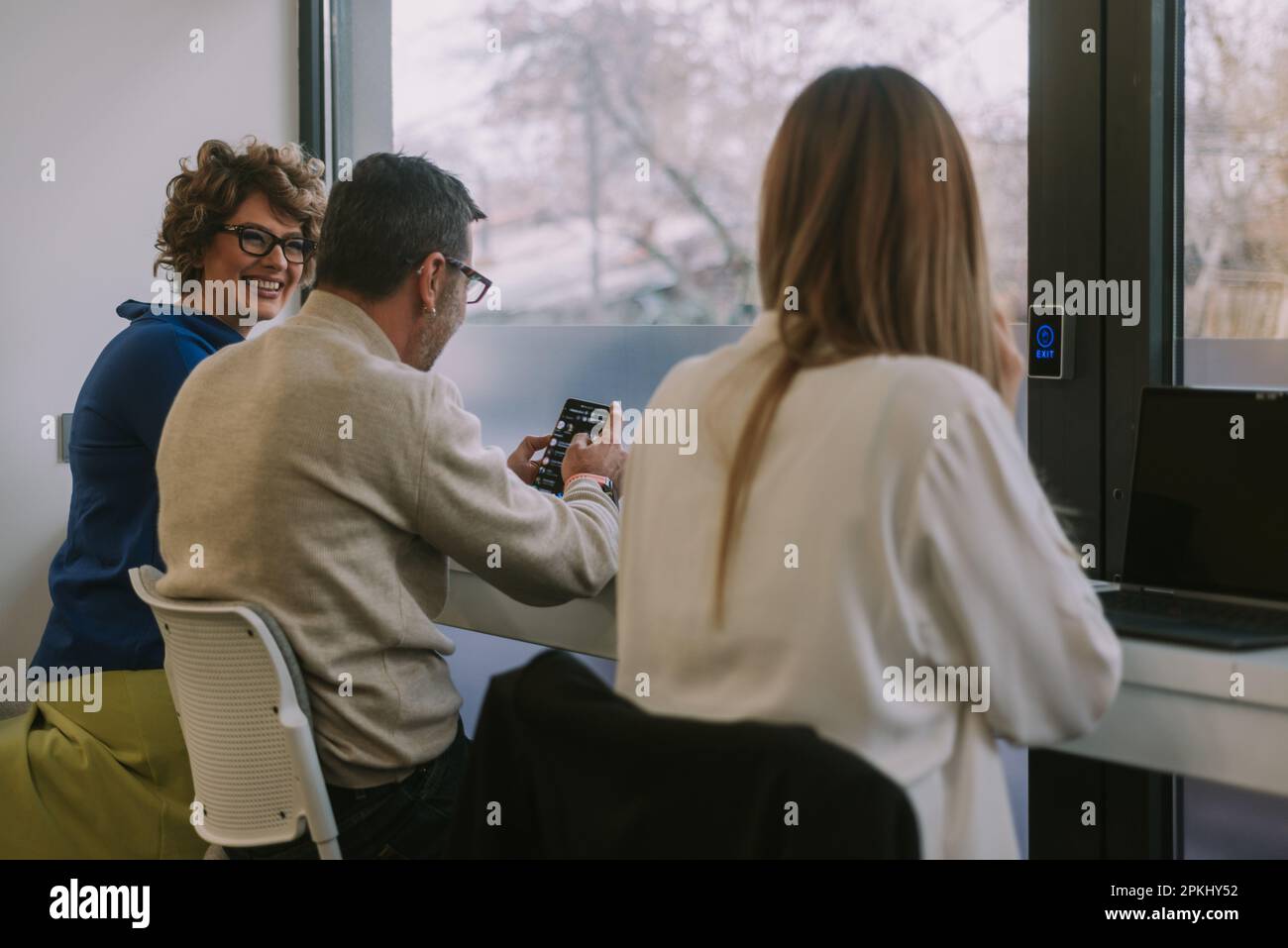 Three inter-generational colleagues working together at the office and ...