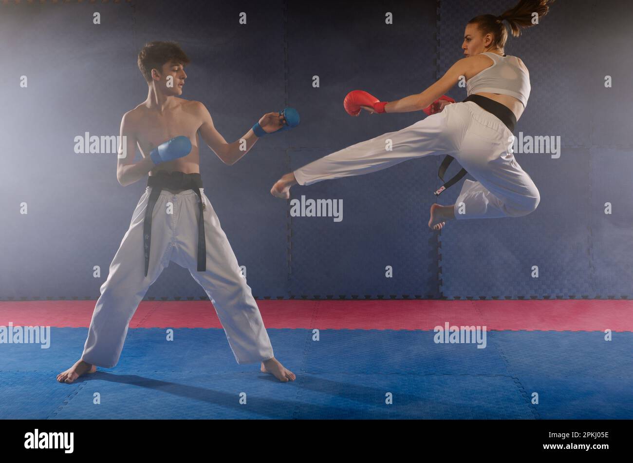 Two strong and good looking karate friends doing the Yoko Tobi Geri ...