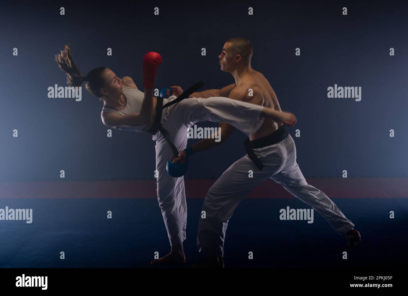 Two strong karate friends doing the Mawashi Geri practice at the studio ...