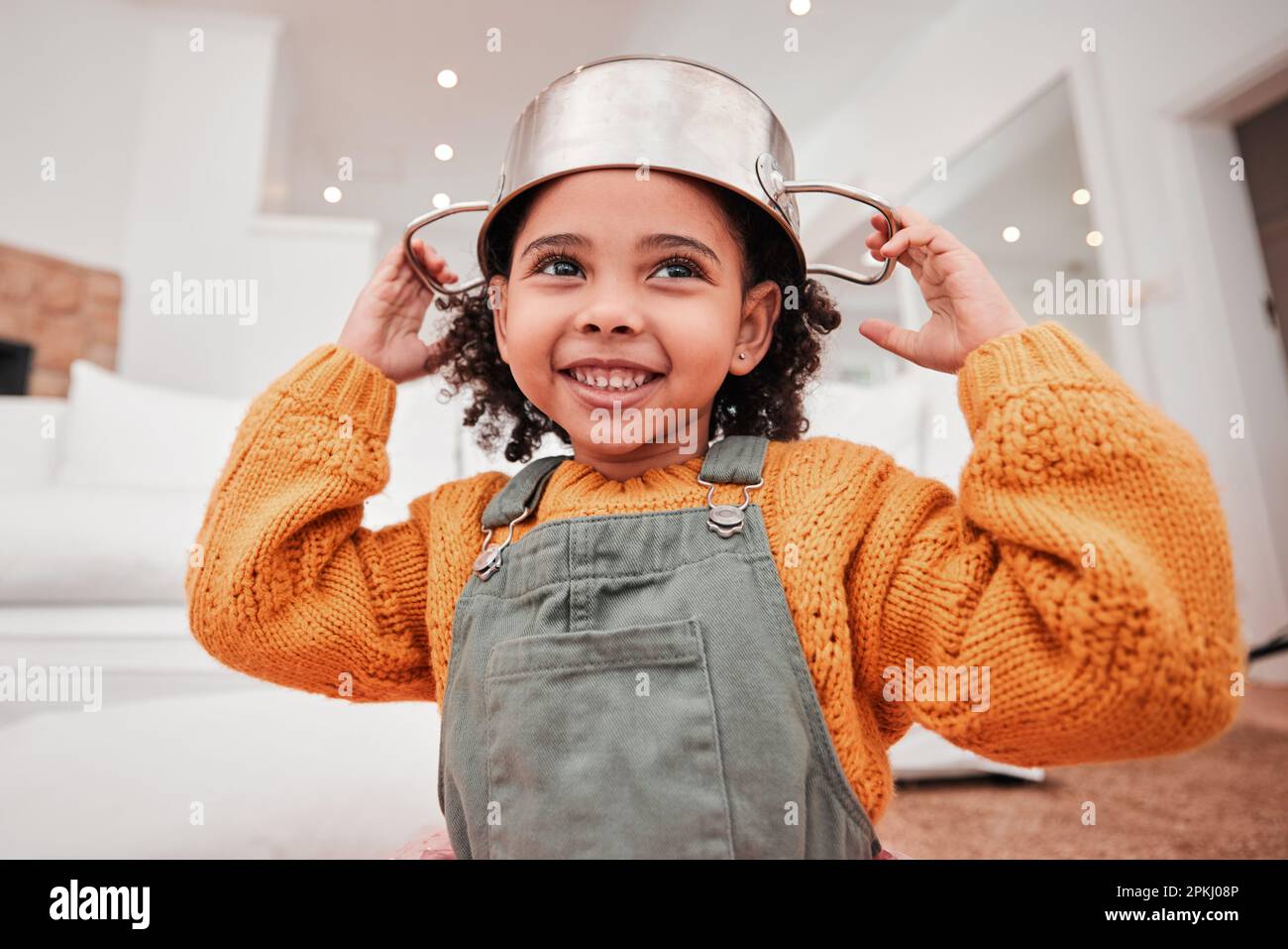 Children, playing and a girl with a pot on her head in the living room ...