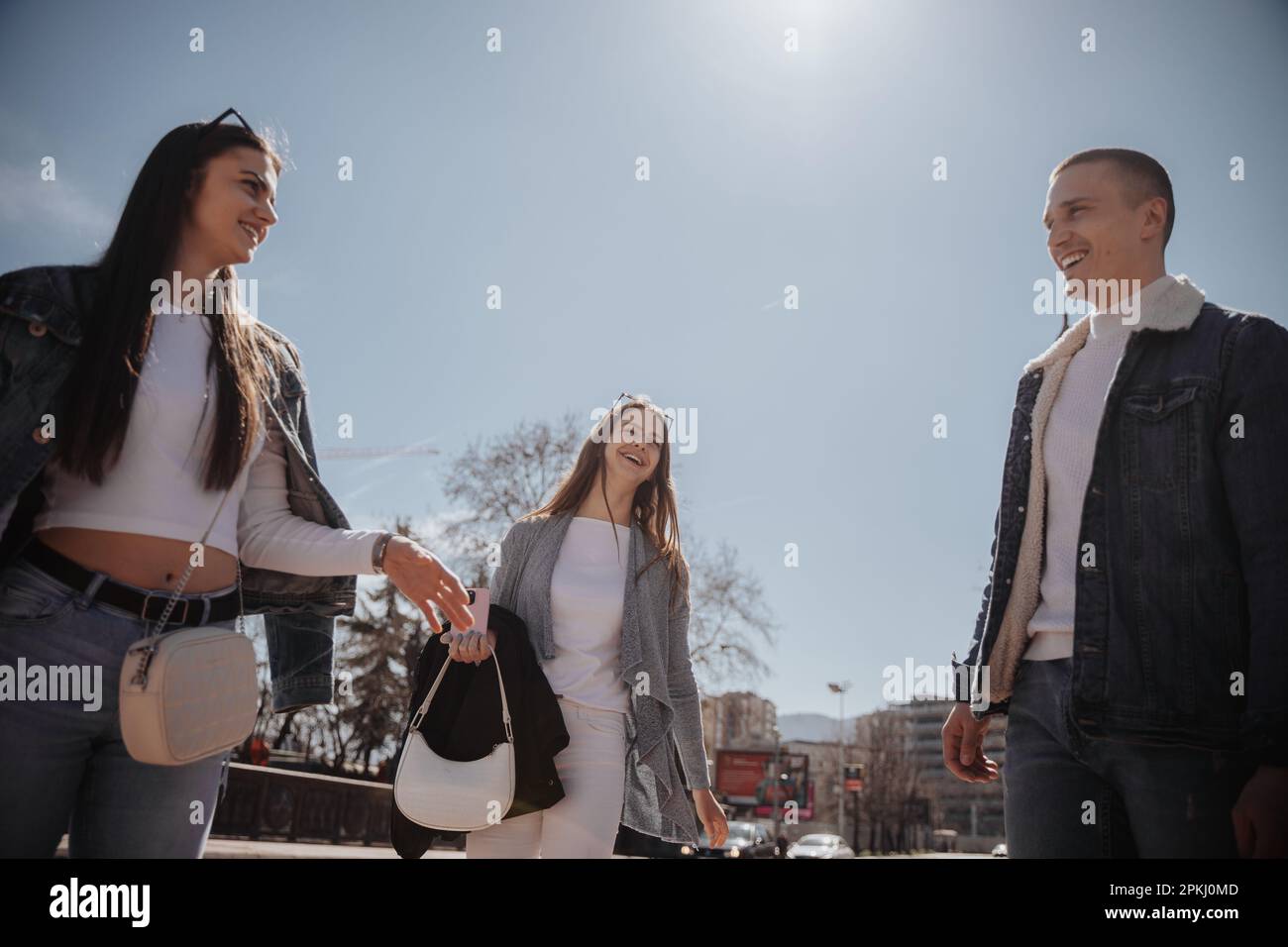 Three close friends laughing together while walking at the city center ...