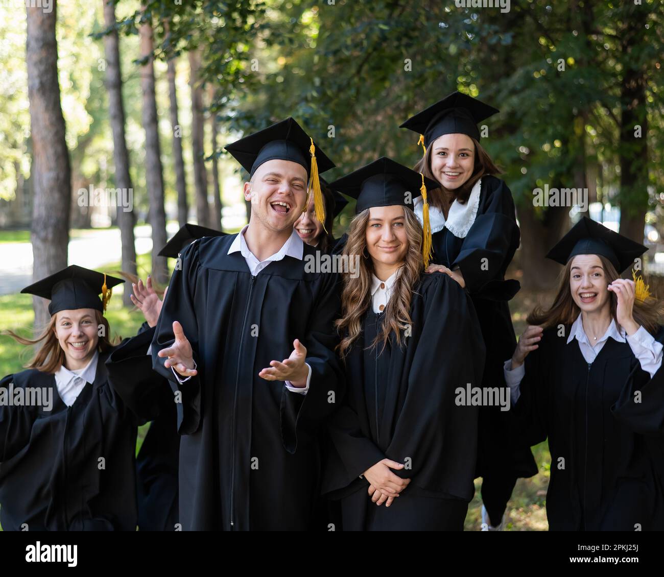 A group of graduates in robes congratulate each other on their ...