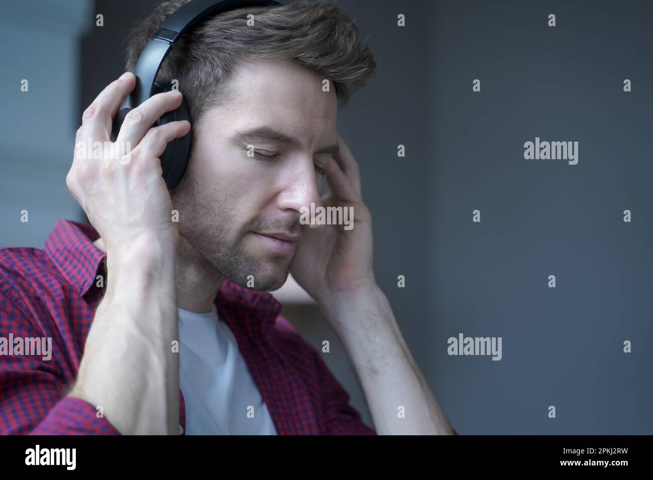 Side view photo of young pleased german man with closed eyes listening ...