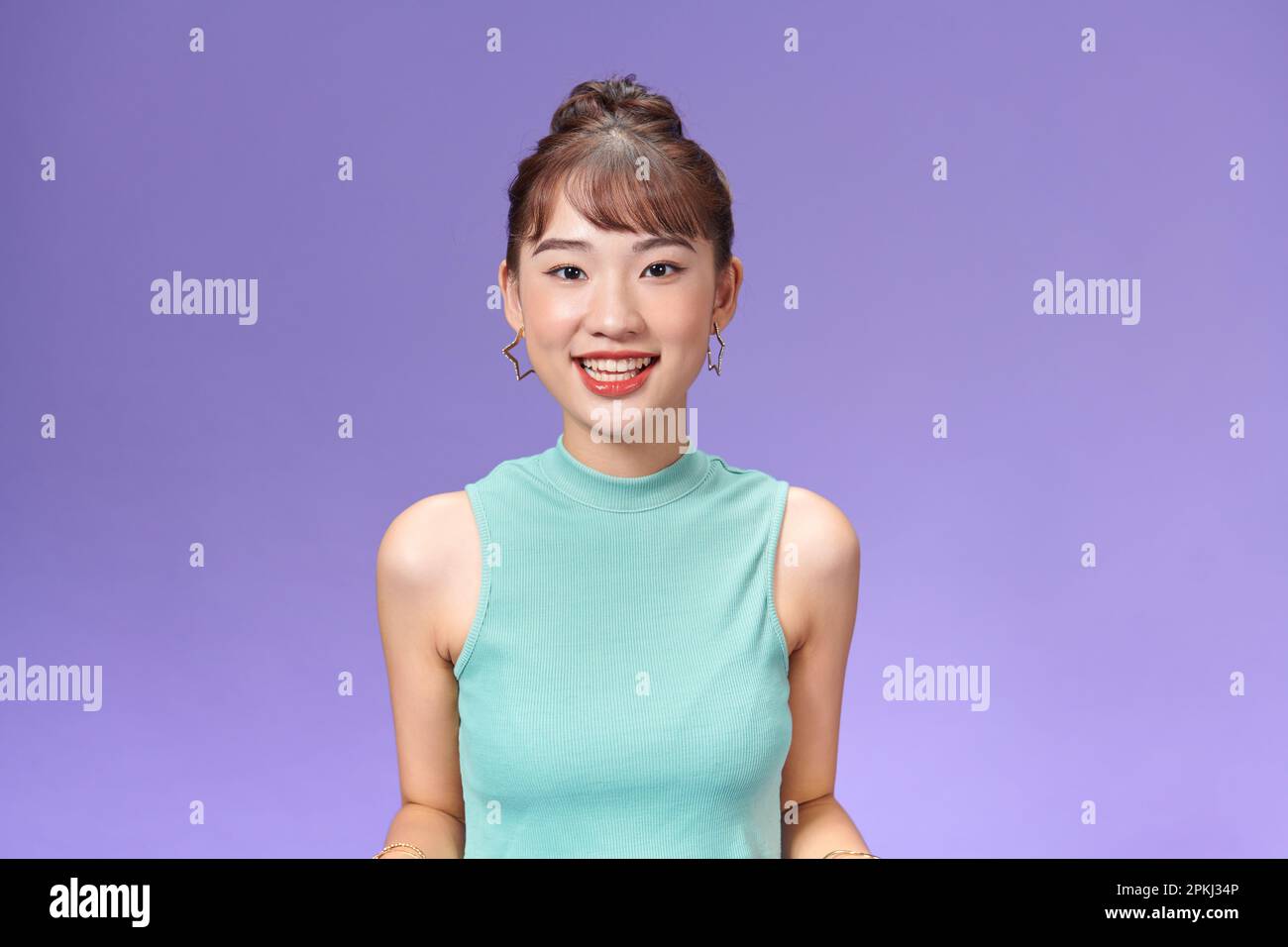 Portrait of happy pretty girl with dimples smiling over purple ...