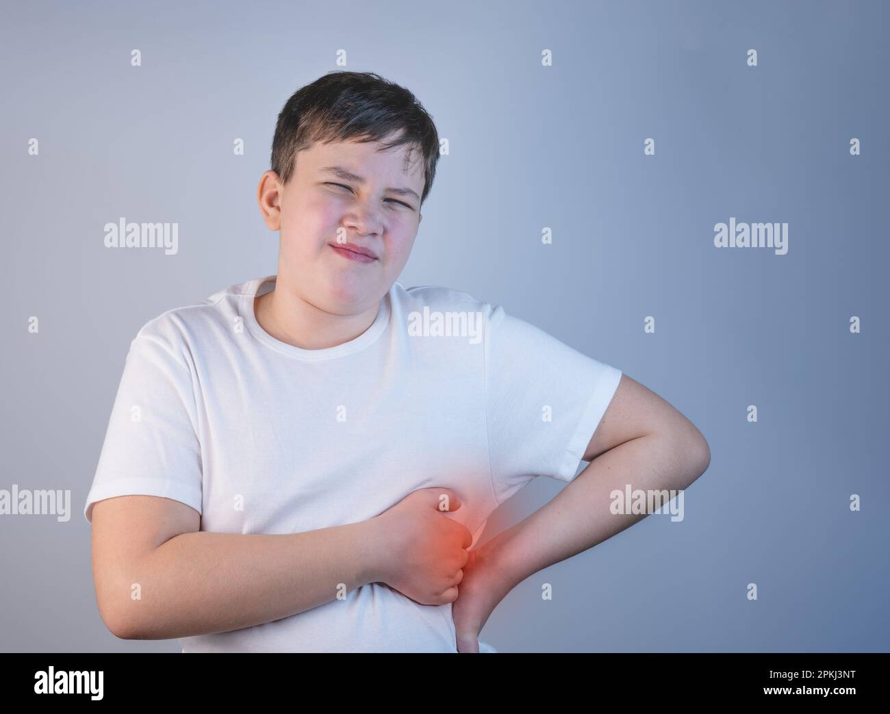 A young man suffering from pain in his side or liver. The teenager ...