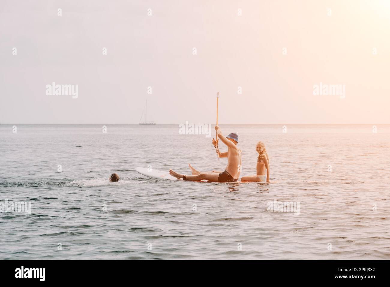Family sea sup. Young happy father with his son and daughter Floating ...