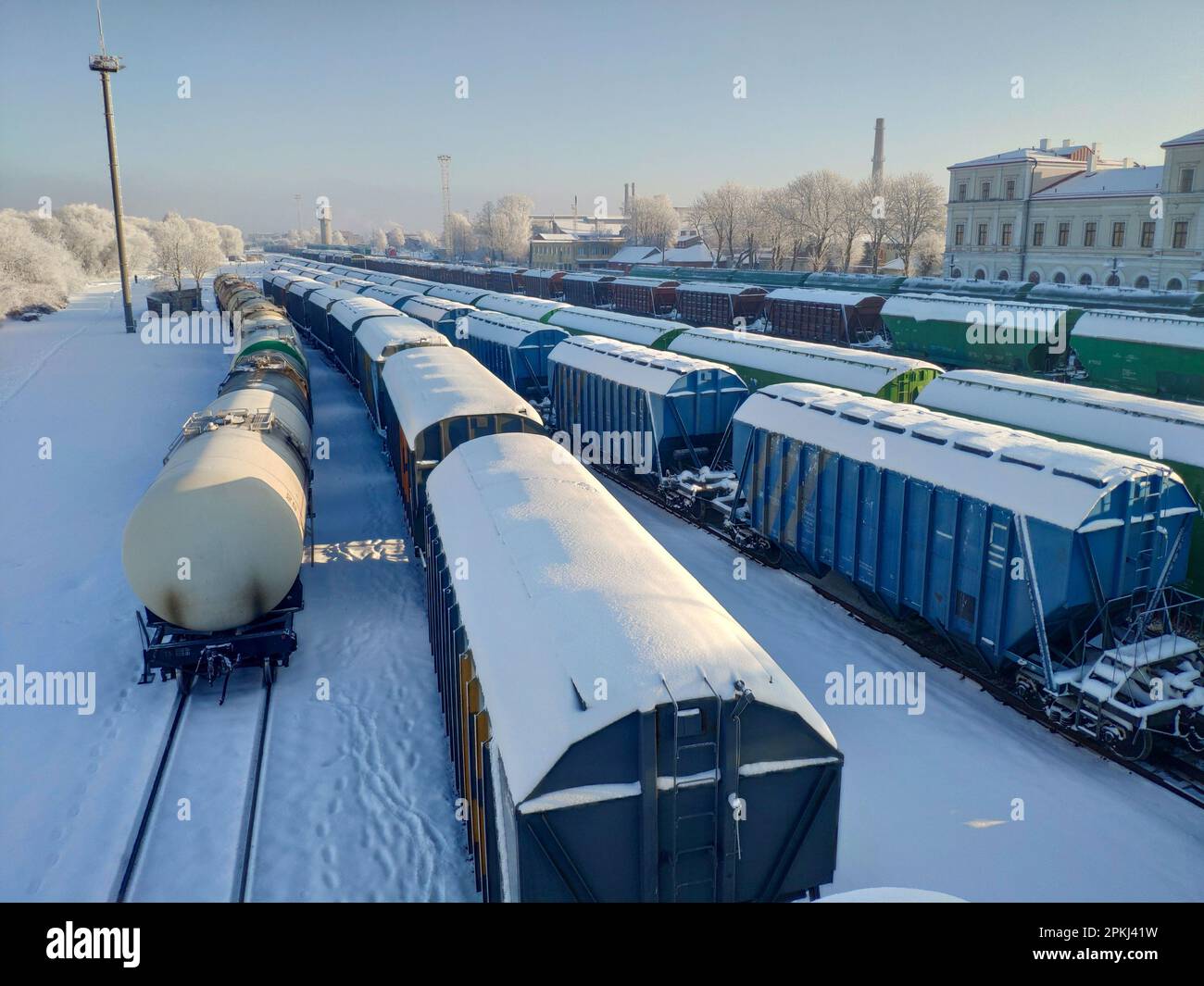 Train station full with cargo train cars covered in snow. Railway ...