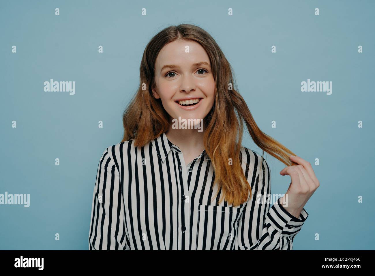 Positive smiling young girl in stripy black and white blouse ...