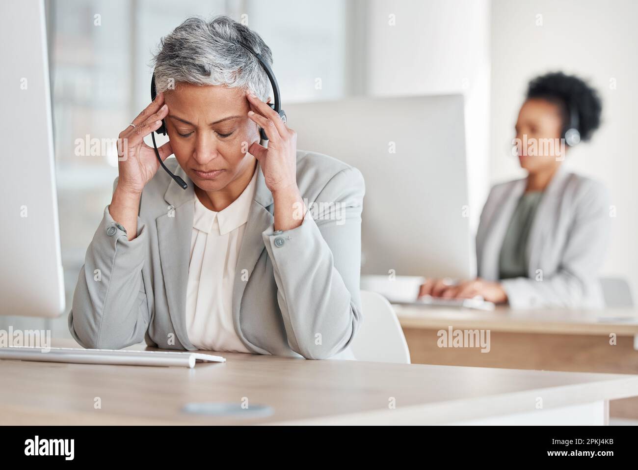 Tired call center woman with headache, fatigue and pain on computer ...