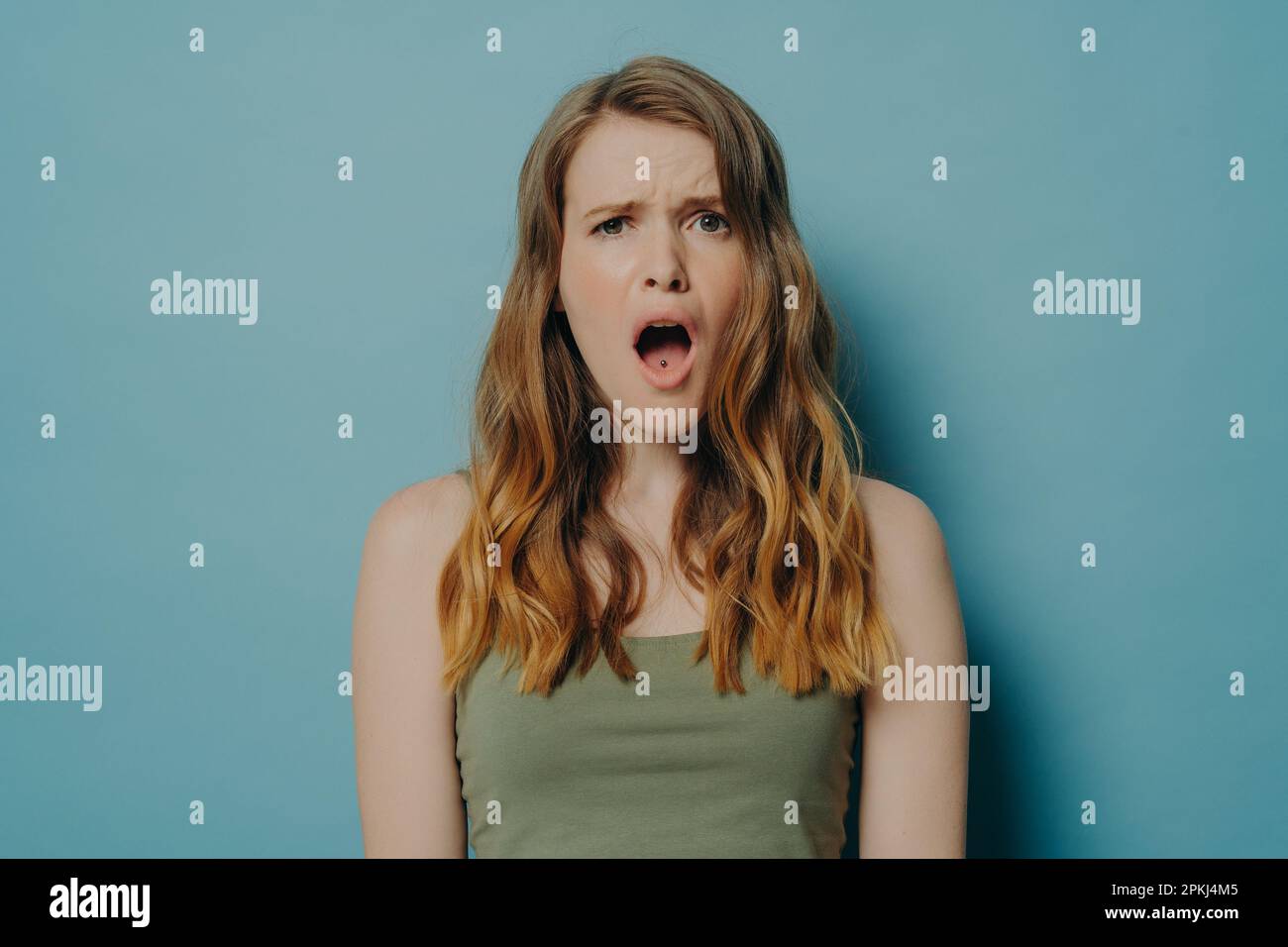 Its awful. Young displeased woman with slightly wavy hair looking at ...