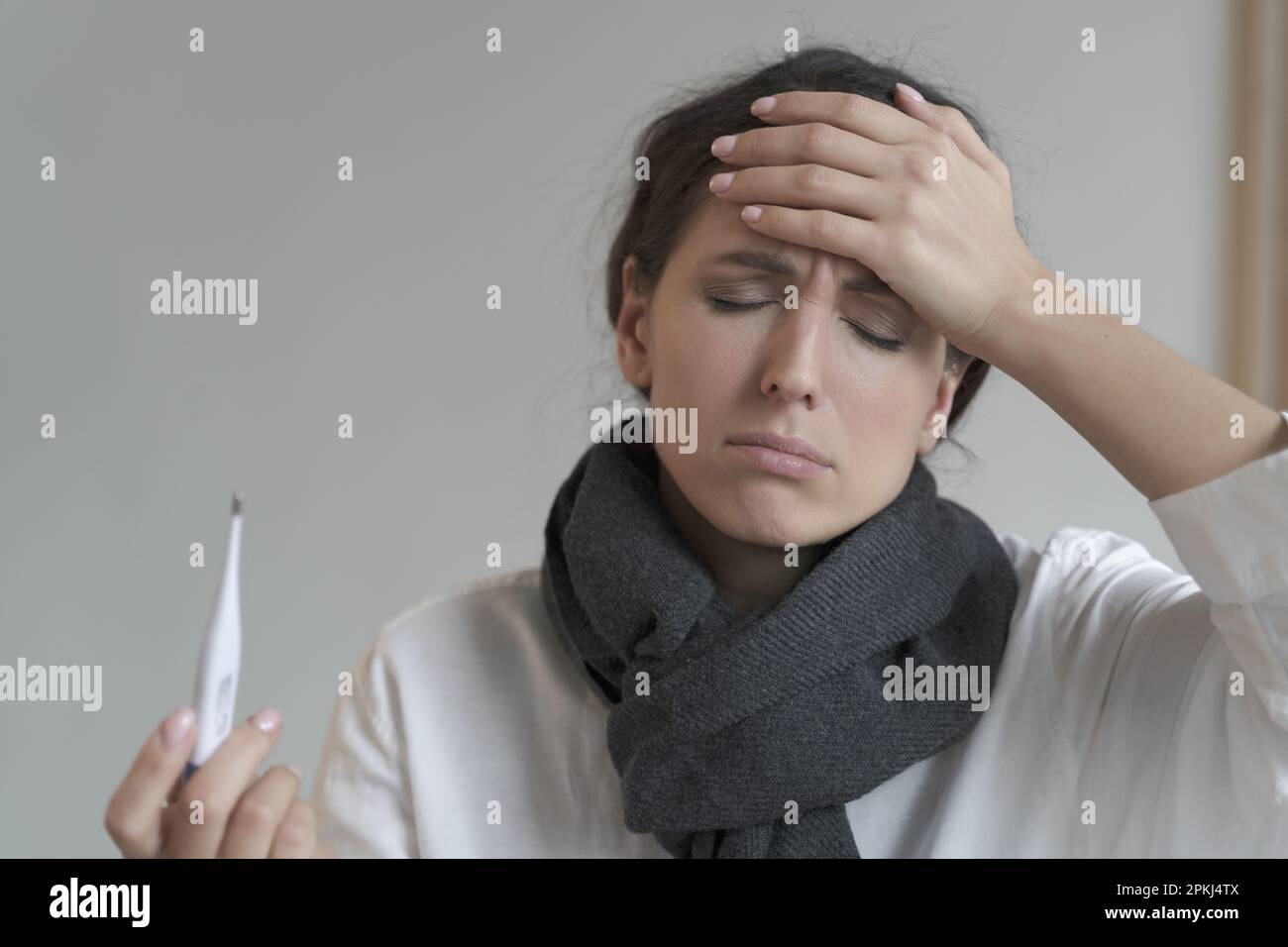 Italian entrepreneur lady tormented by hard work and fever, stands with ...