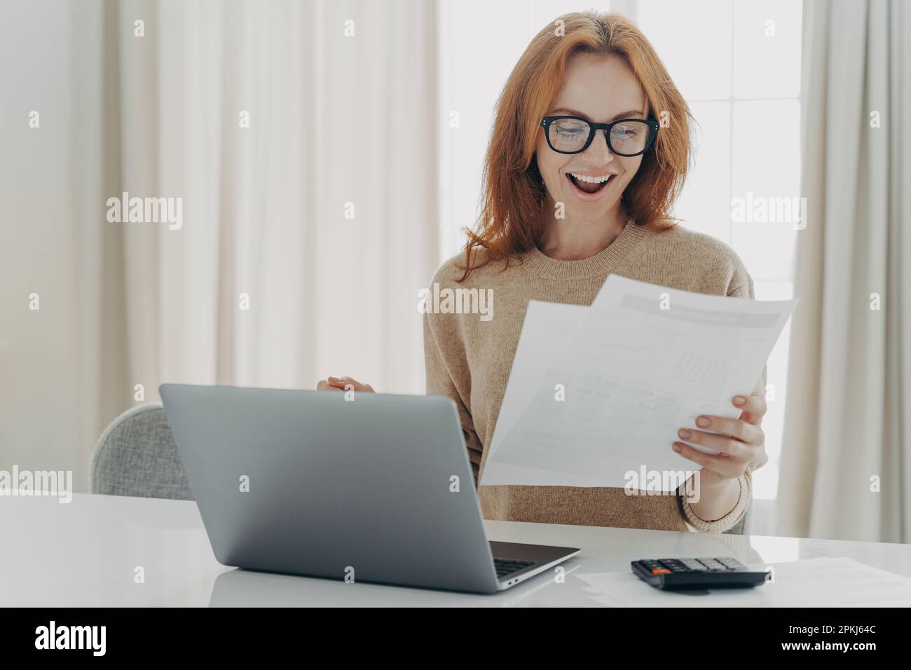 Happy excited redhead woman reading paper letter with notification ...