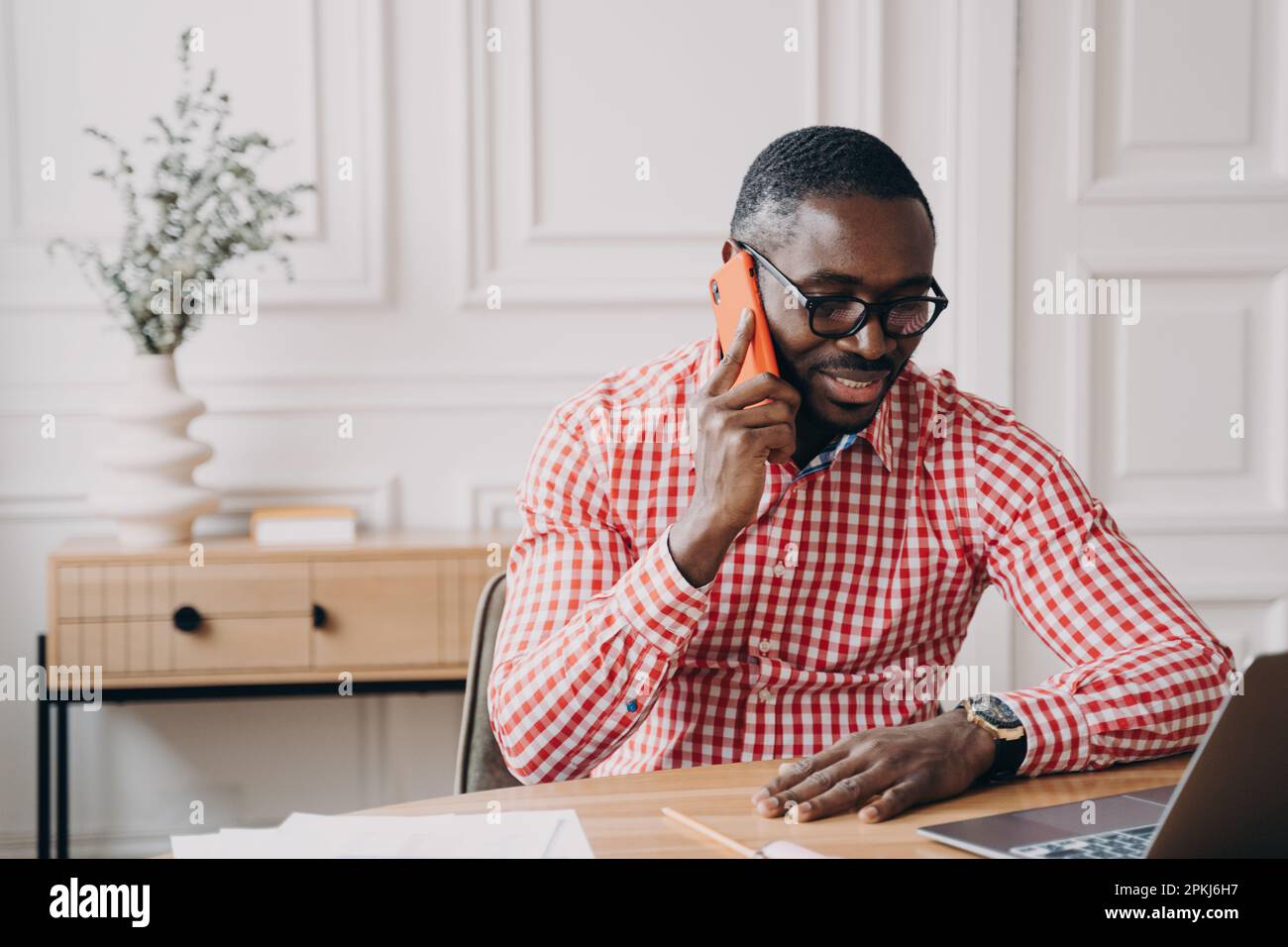 Young modern african businessman talking via mobile phone with client ...