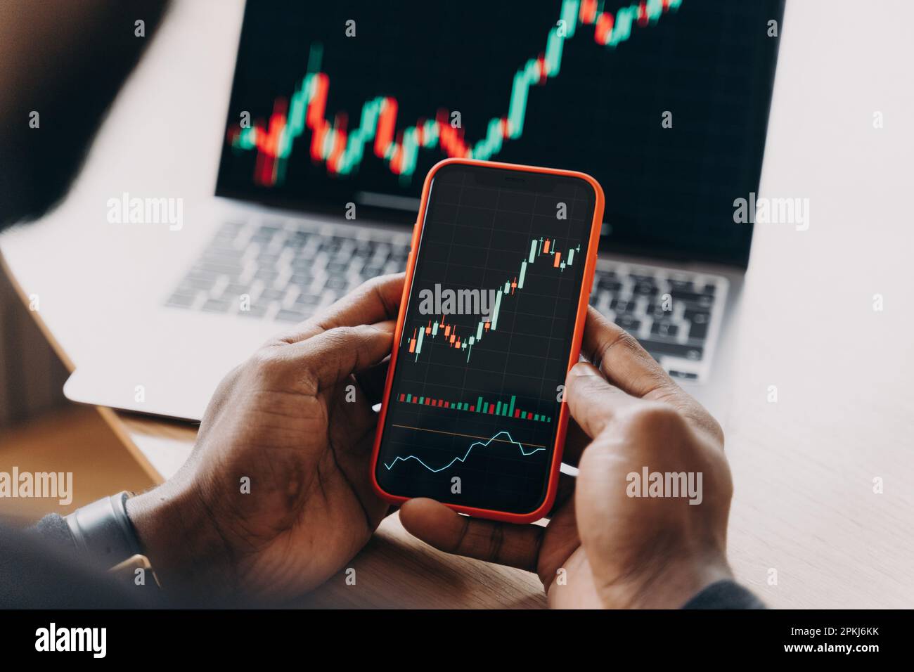 Close up of african man stock trader holding mobile phone against ...