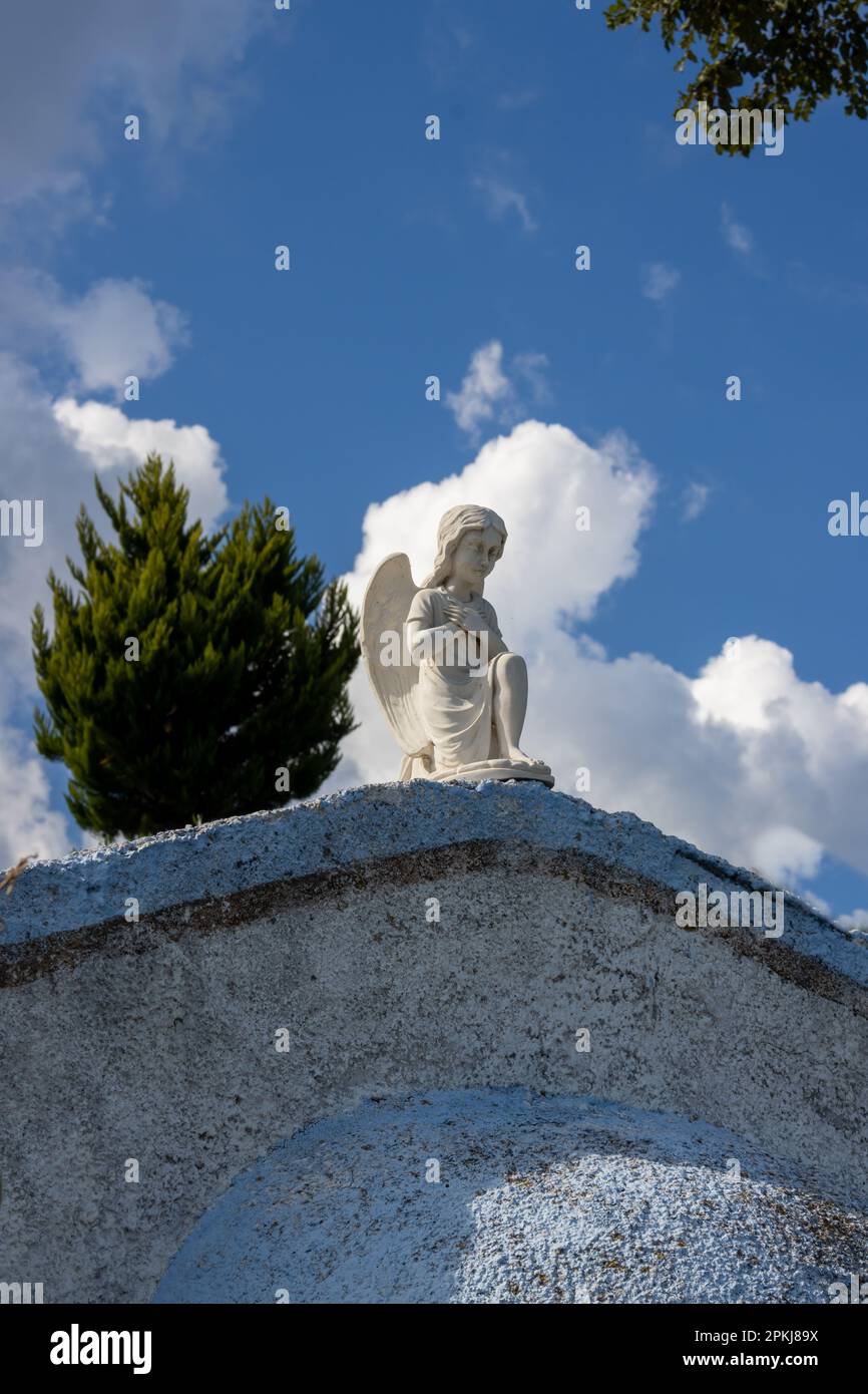 Angel on a roof of small blue chapel, built in a beautiful garden ...