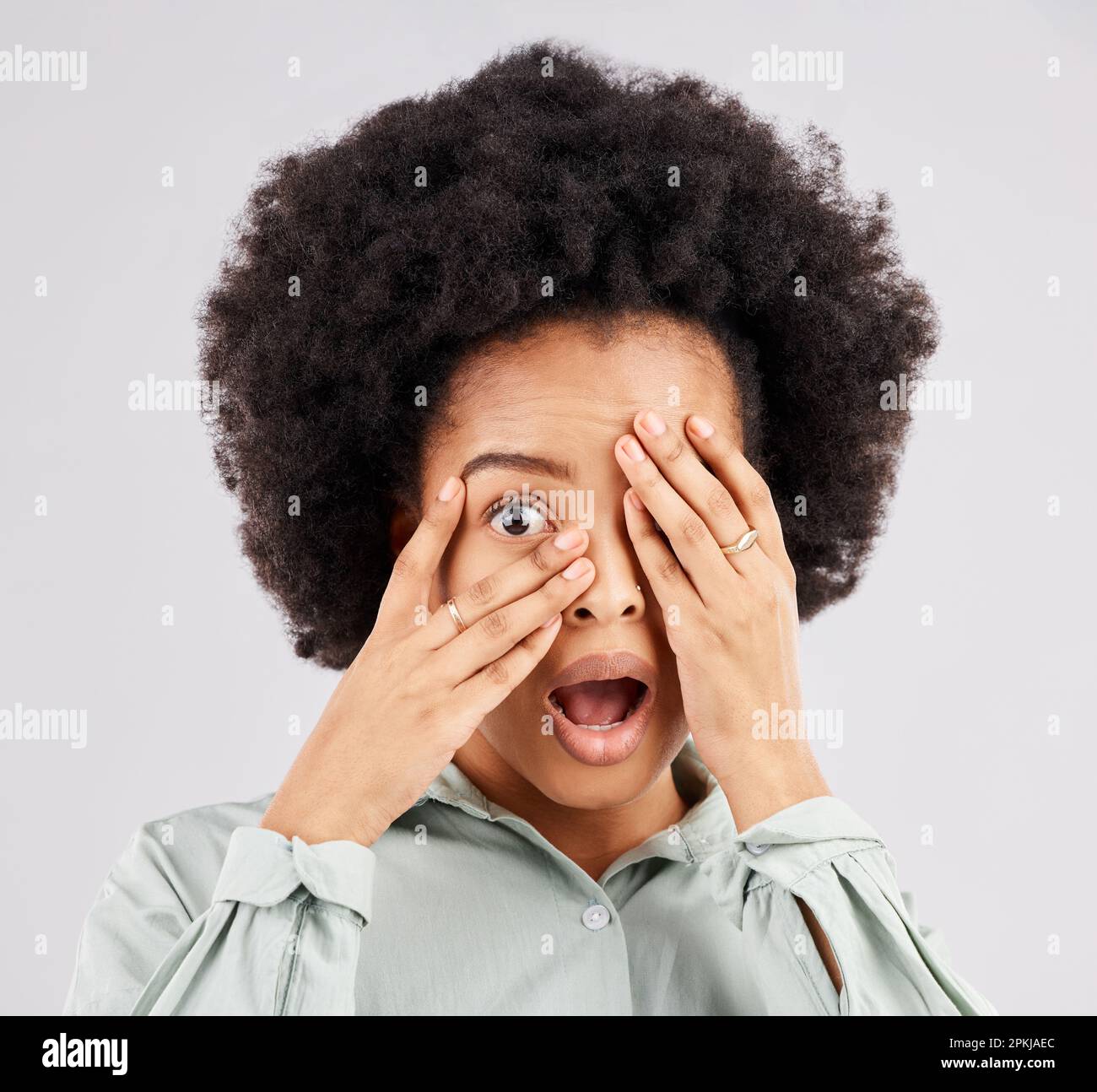 Black woman, shock and hands cover eyes in studio for surprise, wow and omg reaction on white ...