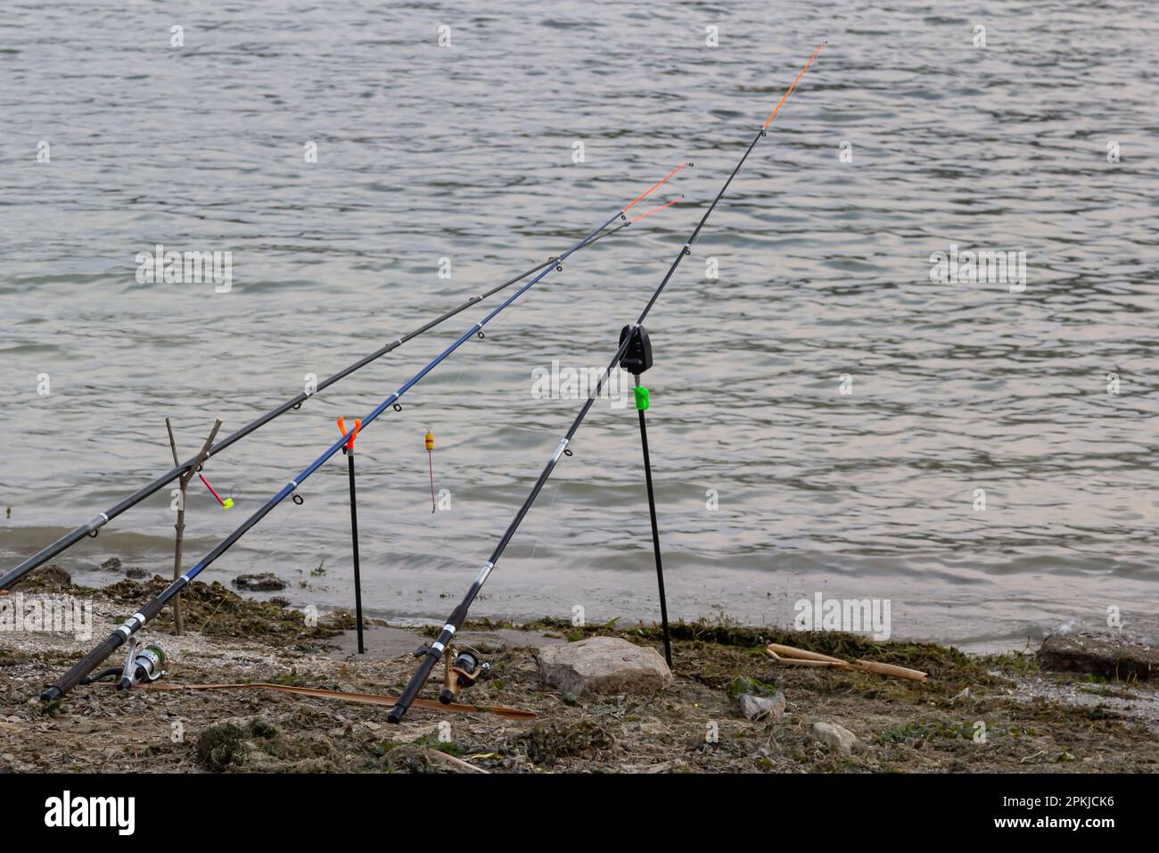 Fishing rods and fishing gear on the river bank, lake coast close up ...